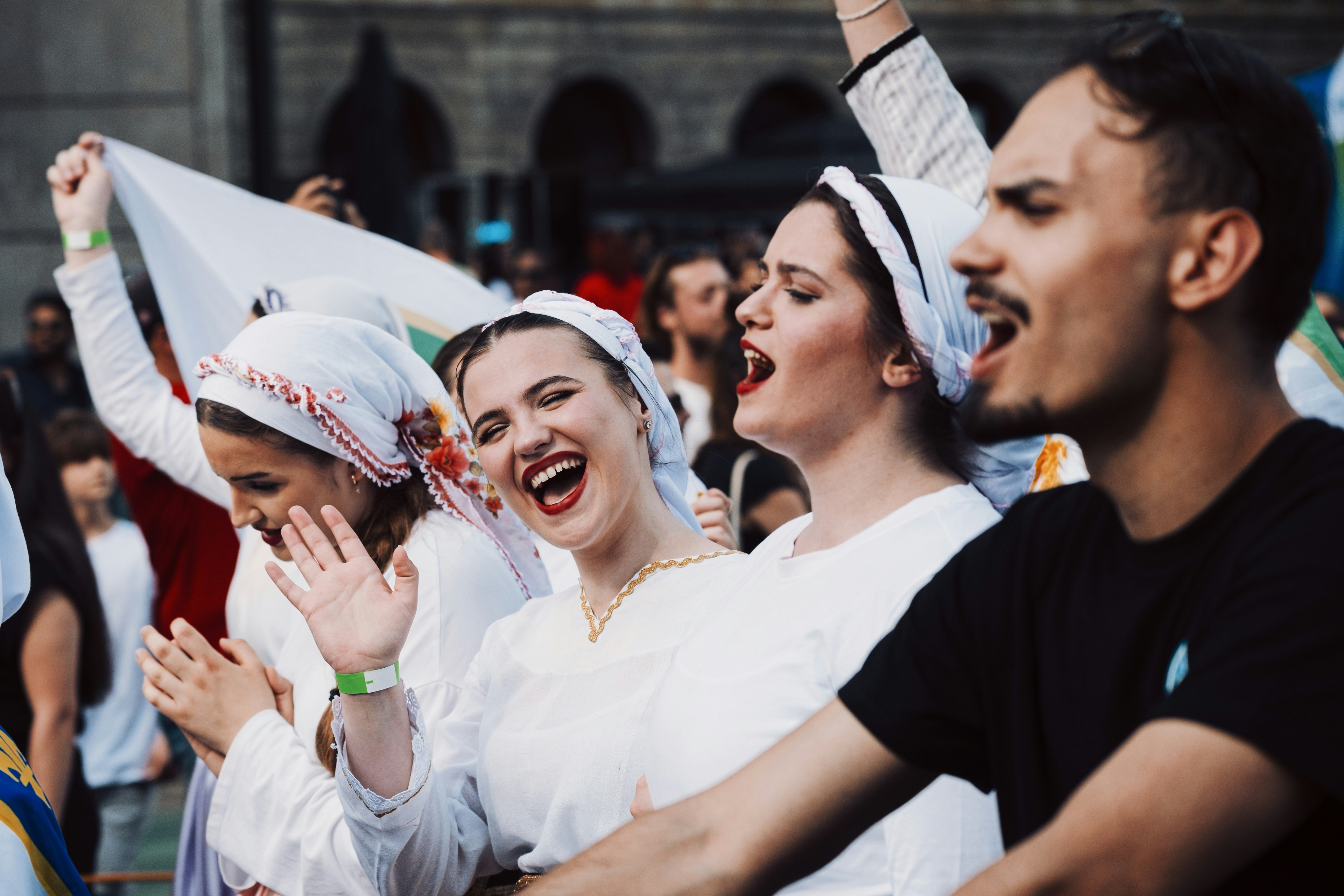 Happy people in traditional white outfits laughing and cheering. photo ...