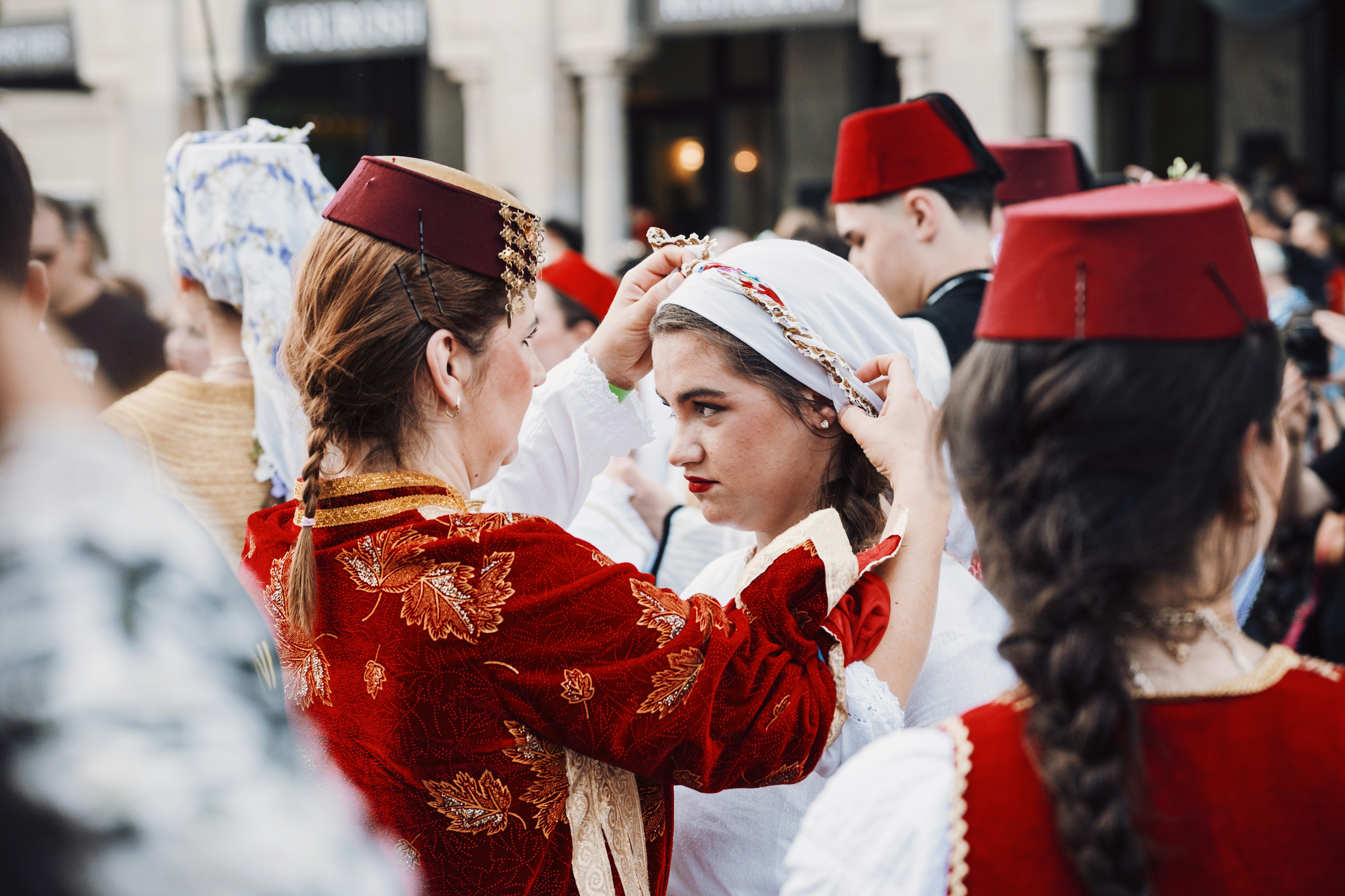 Caretaker's gesture: a ceremonial moment in red and lace