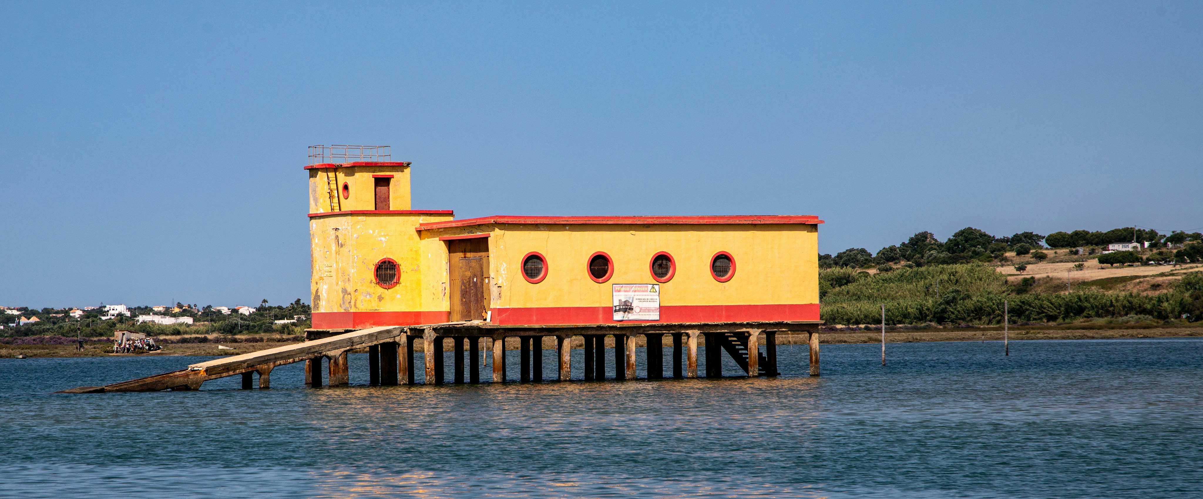 Harbor House on Stilts: A Bold Yellow Keep Above Calm Waters