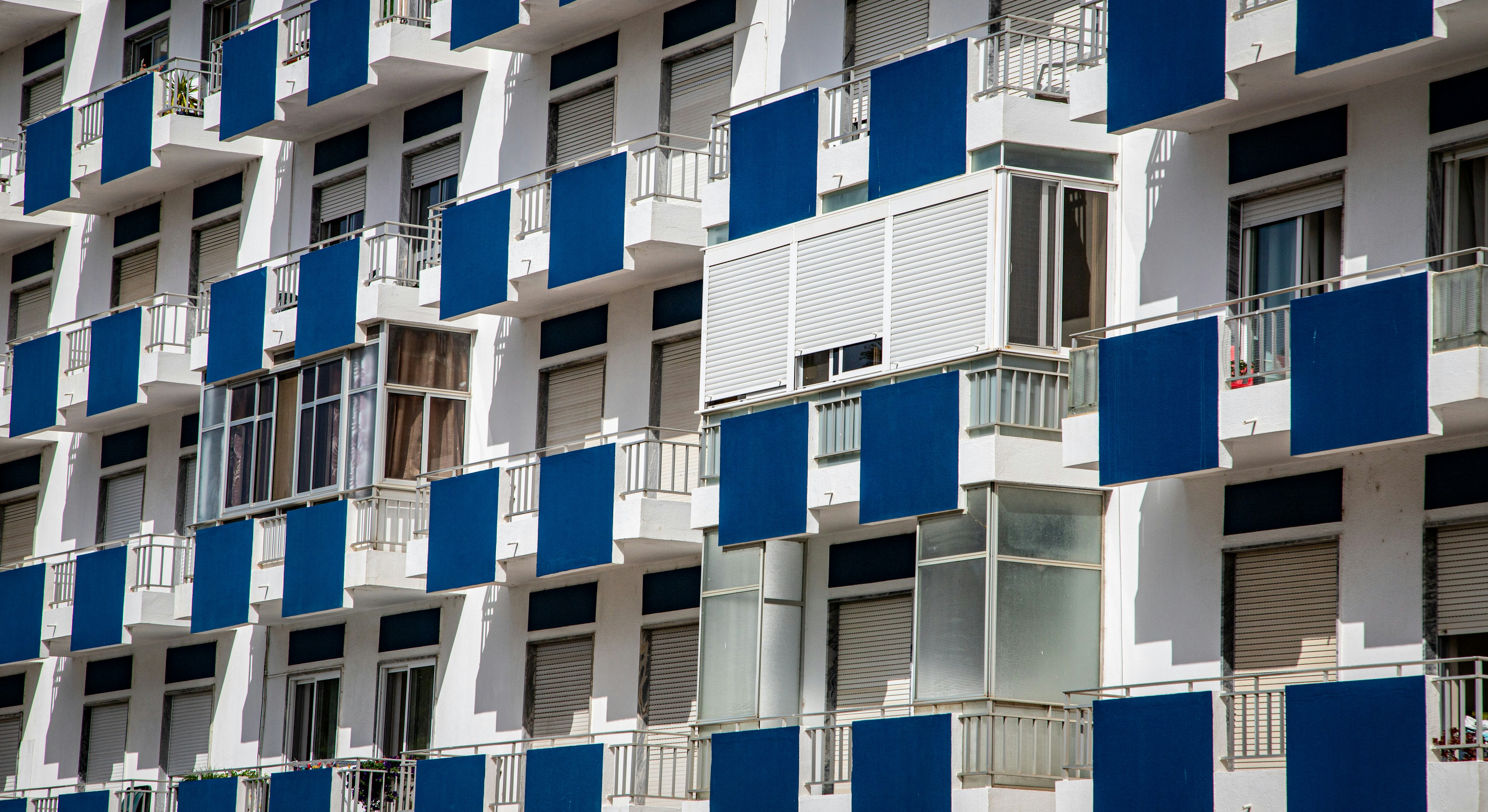 Grid of Blue Panels: Facade Geometry and Light Play on a Modern Block