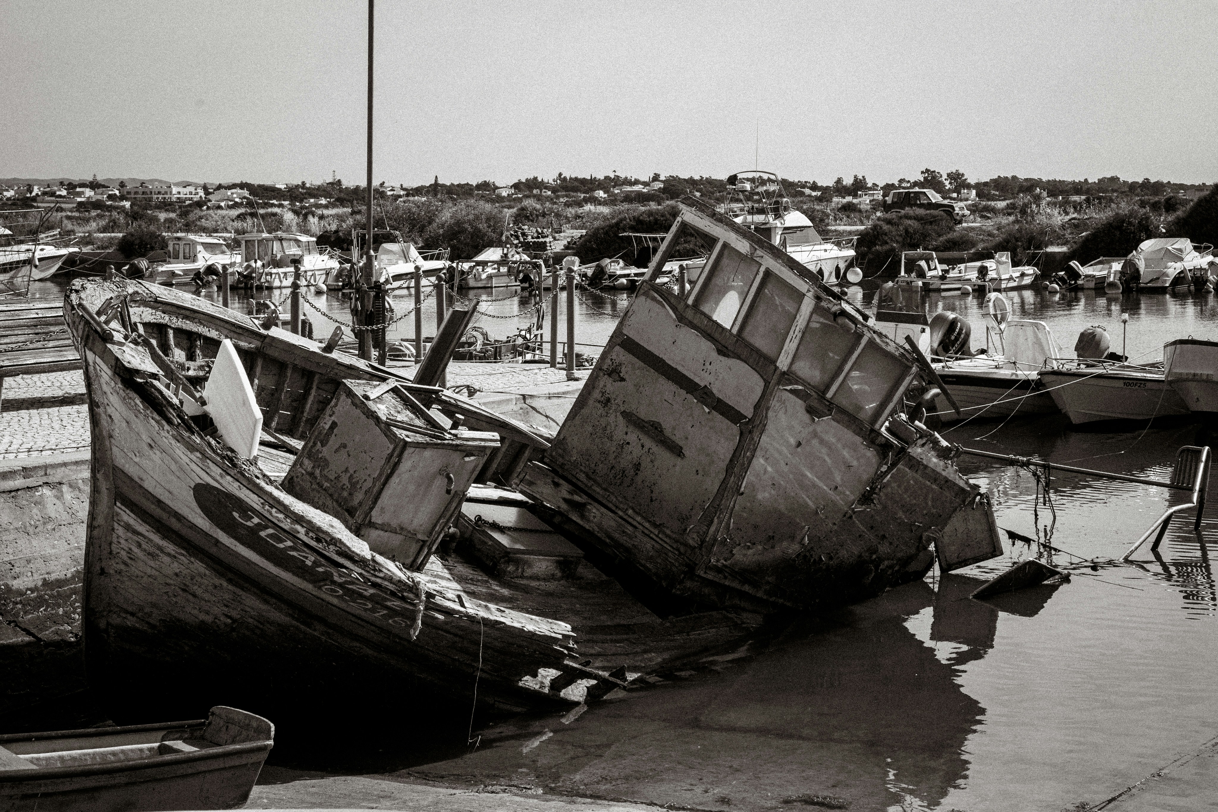 Sunken Craft at Dusk: Boats and their Shadowed Wake