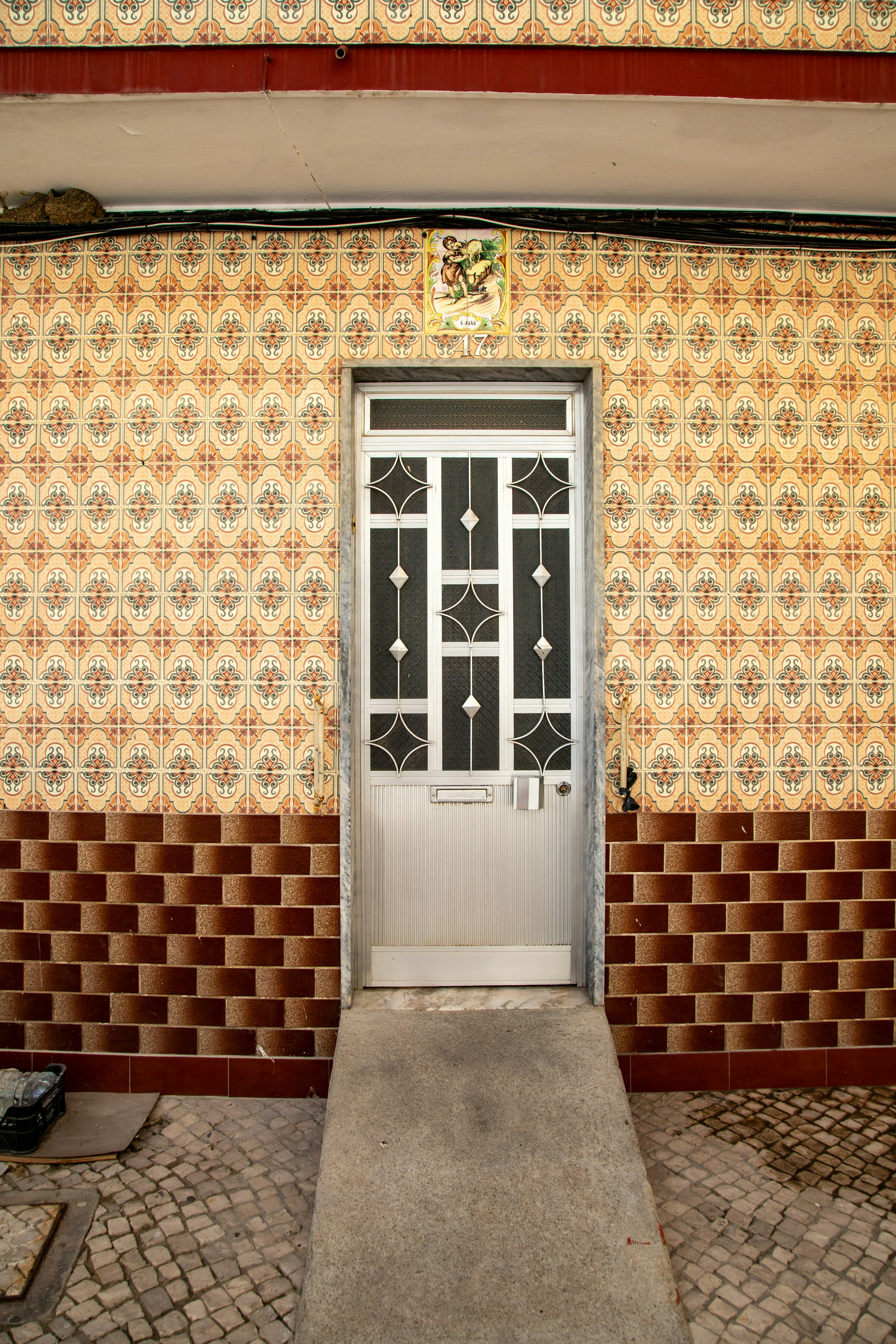 Patterned Tile Facade Leads to a Weathered Door