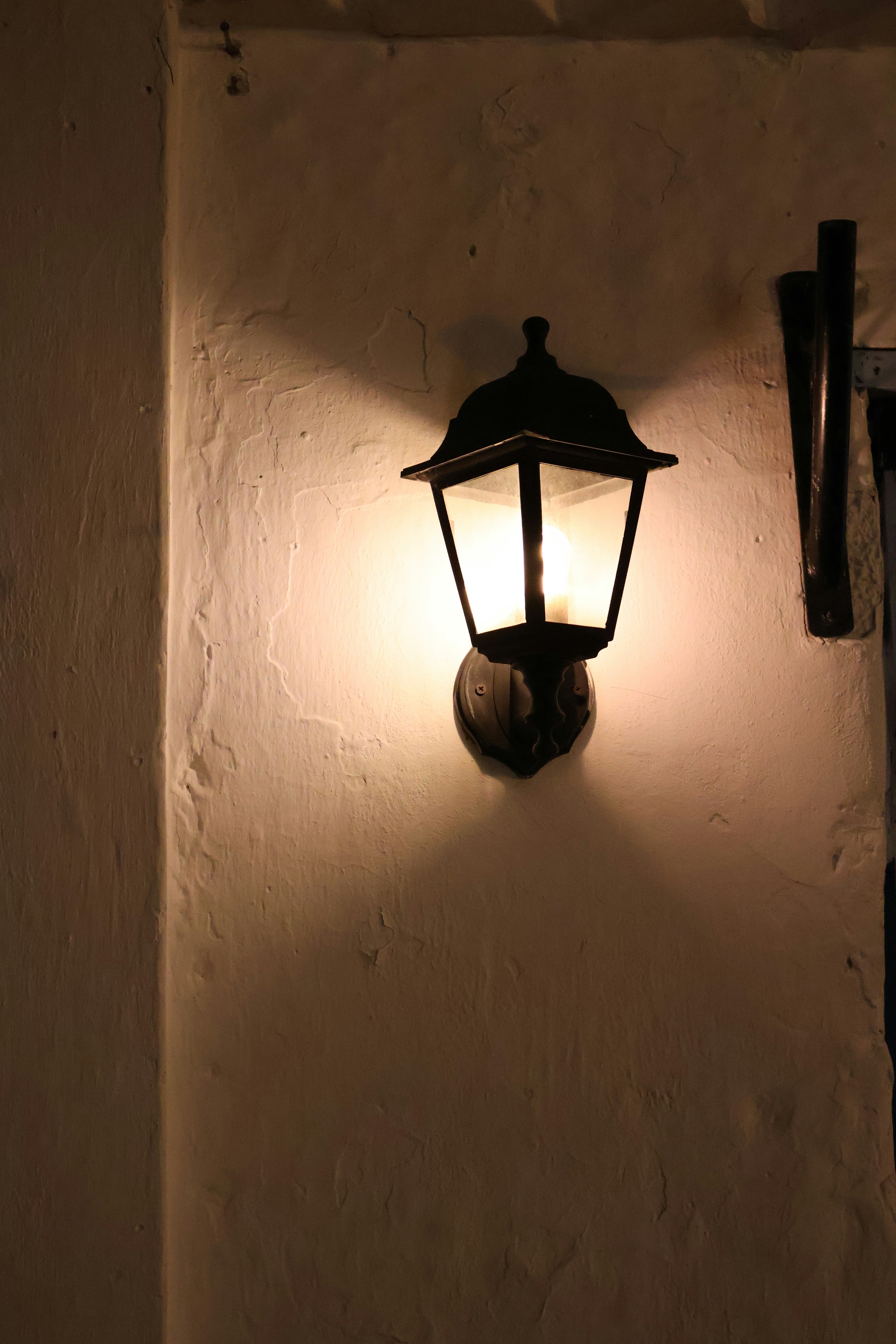 Warm Glow on Weathered Walls: An Exterior Lantern at Dusk