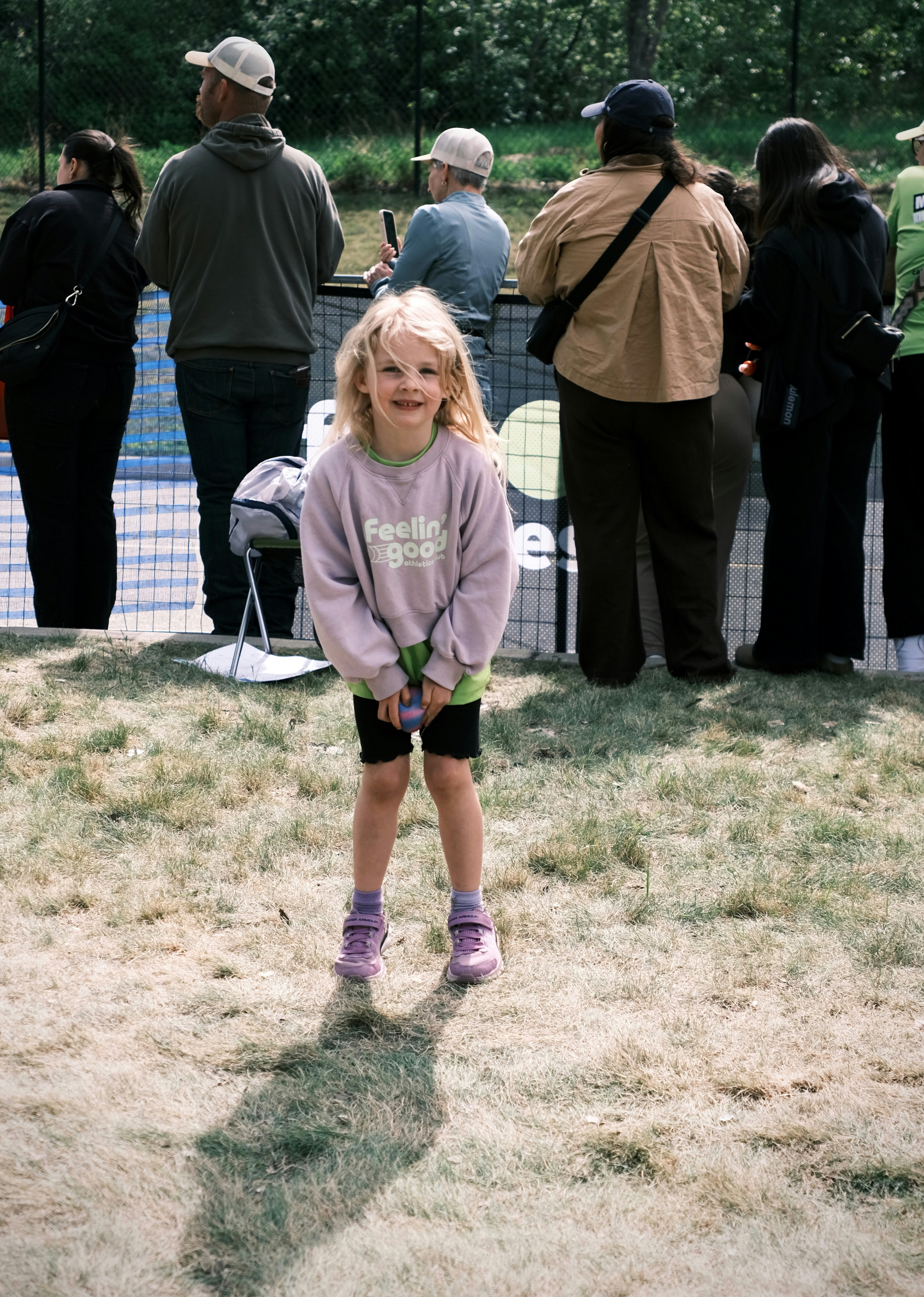 Center Stage: A Daisy-Hooded Child at the Park’s Edge