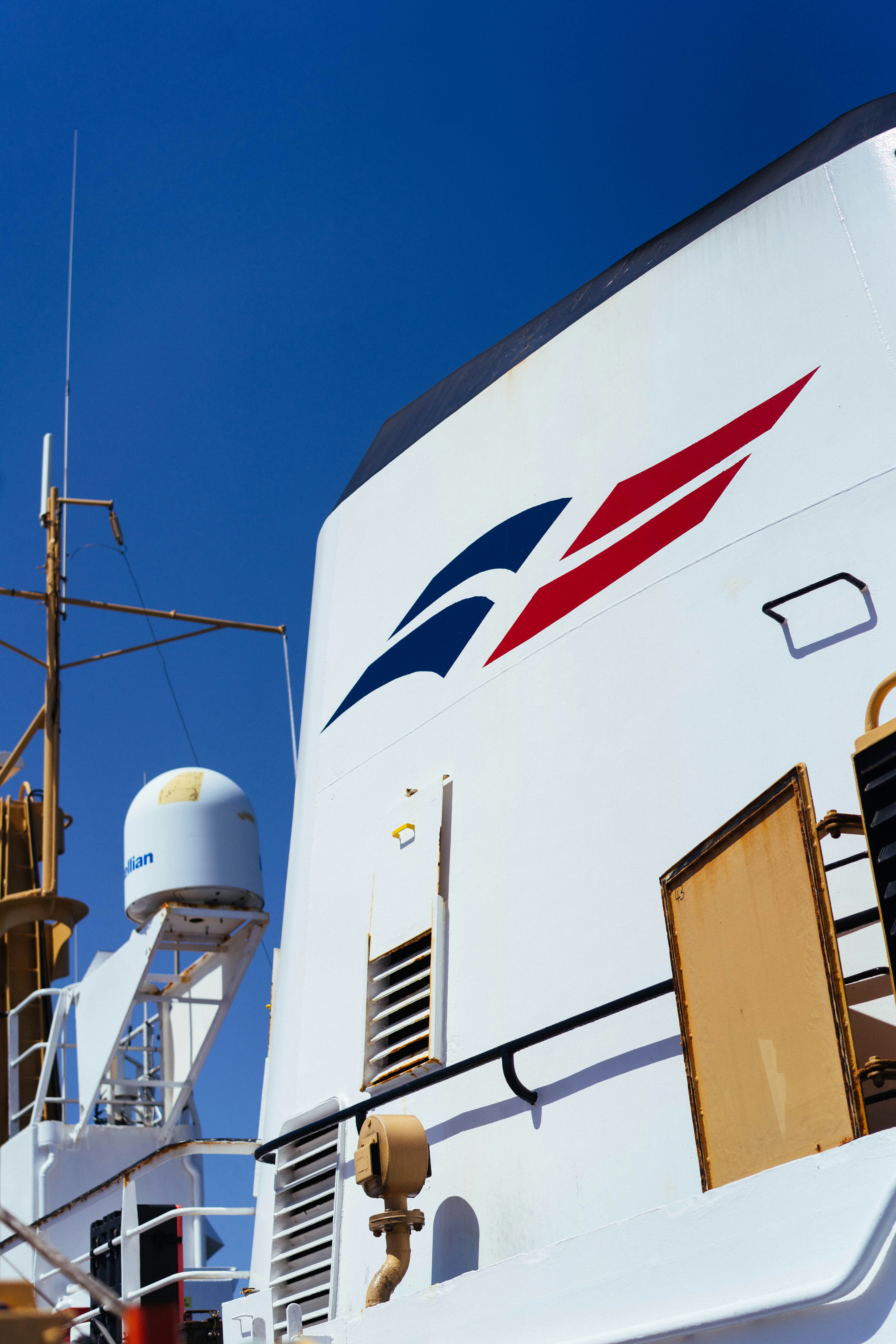 Blue Sky, White Vessel: A Bold Logo on the Hull