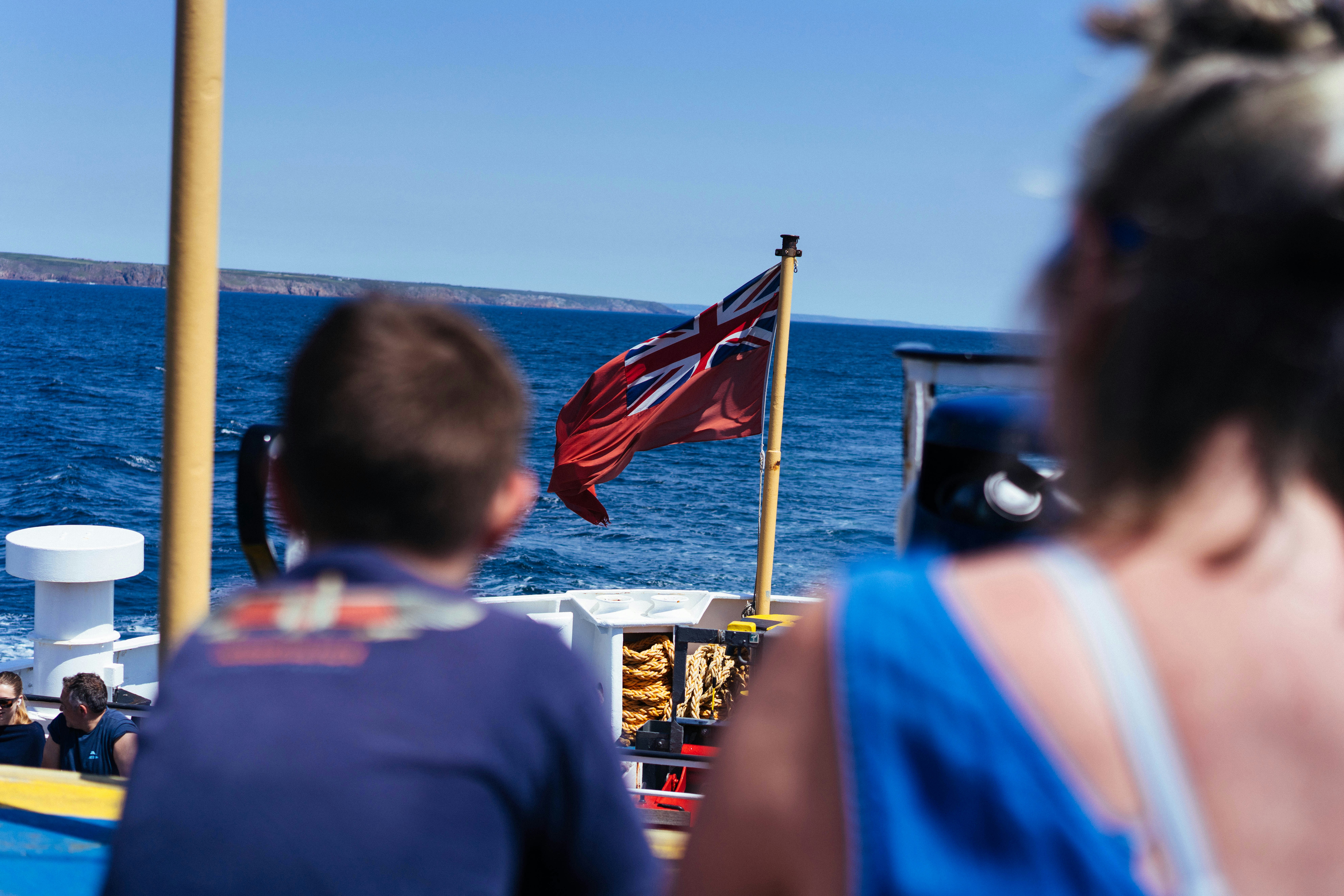 Flag over the Sea: Passengers on Deck with a Blown Flag