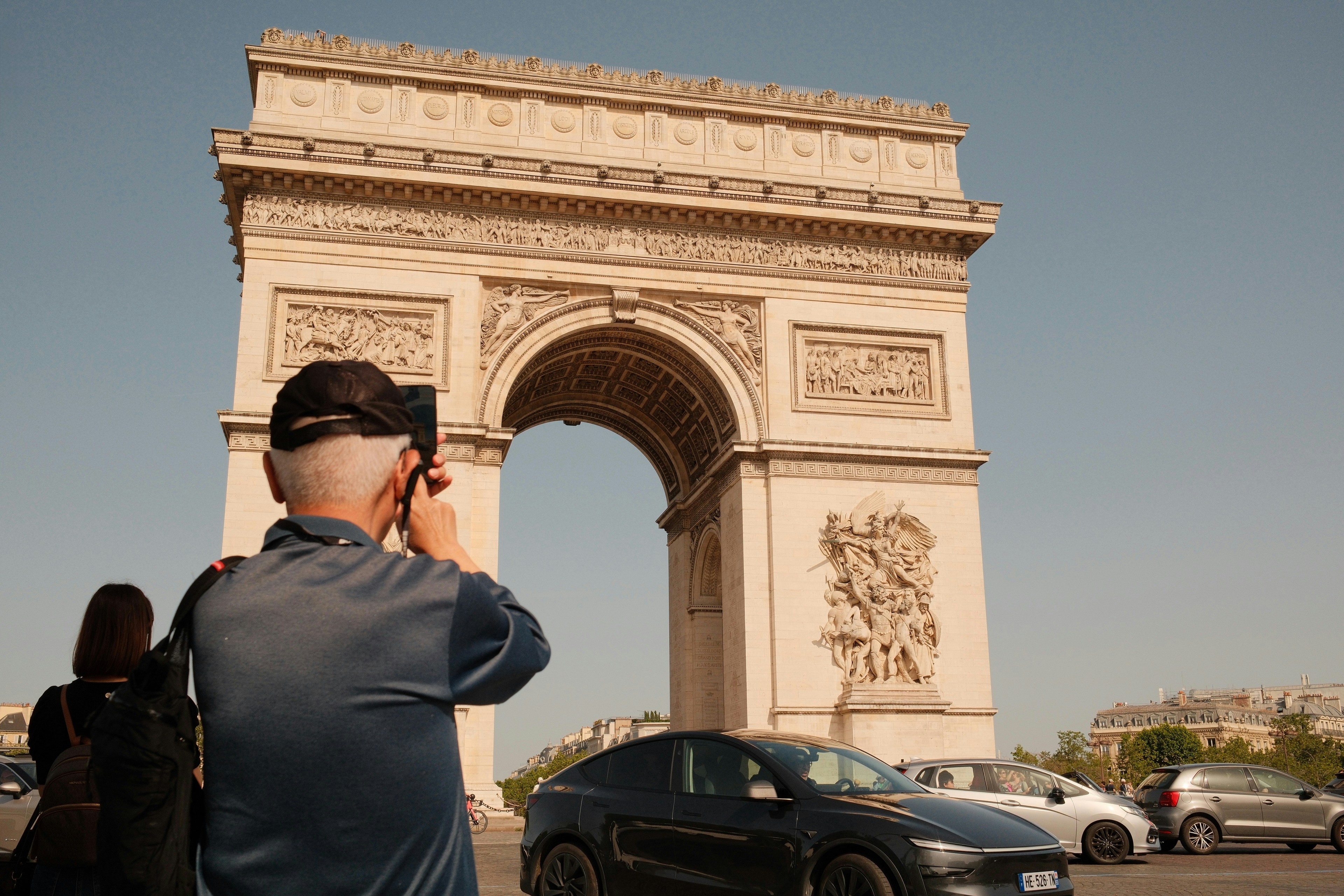 Lens on the Arc: A Photographer Captures the Arc de Triomphe from a Busy Foreground