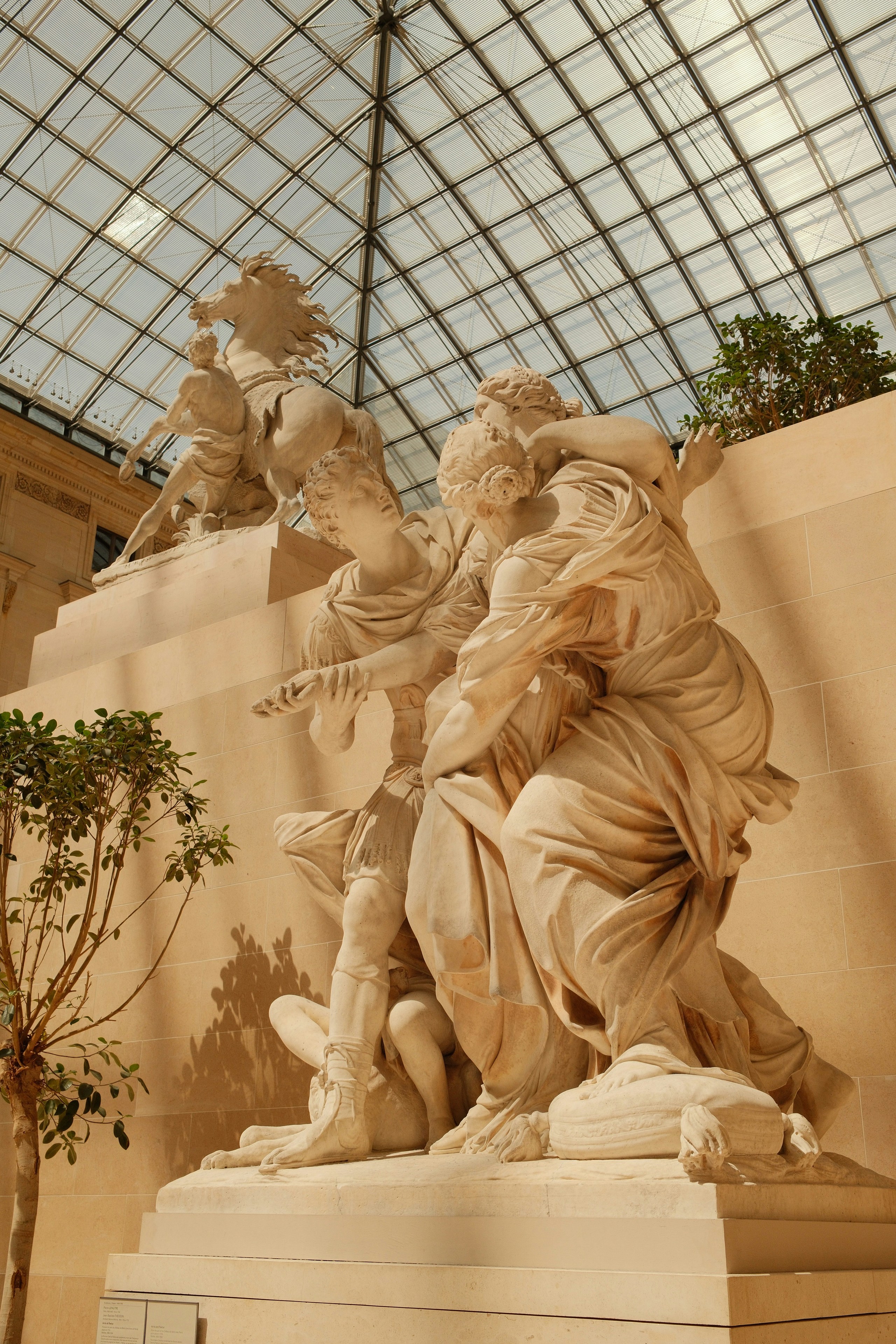 Statuesque drama under glass: classical sculpture bathed in amber light