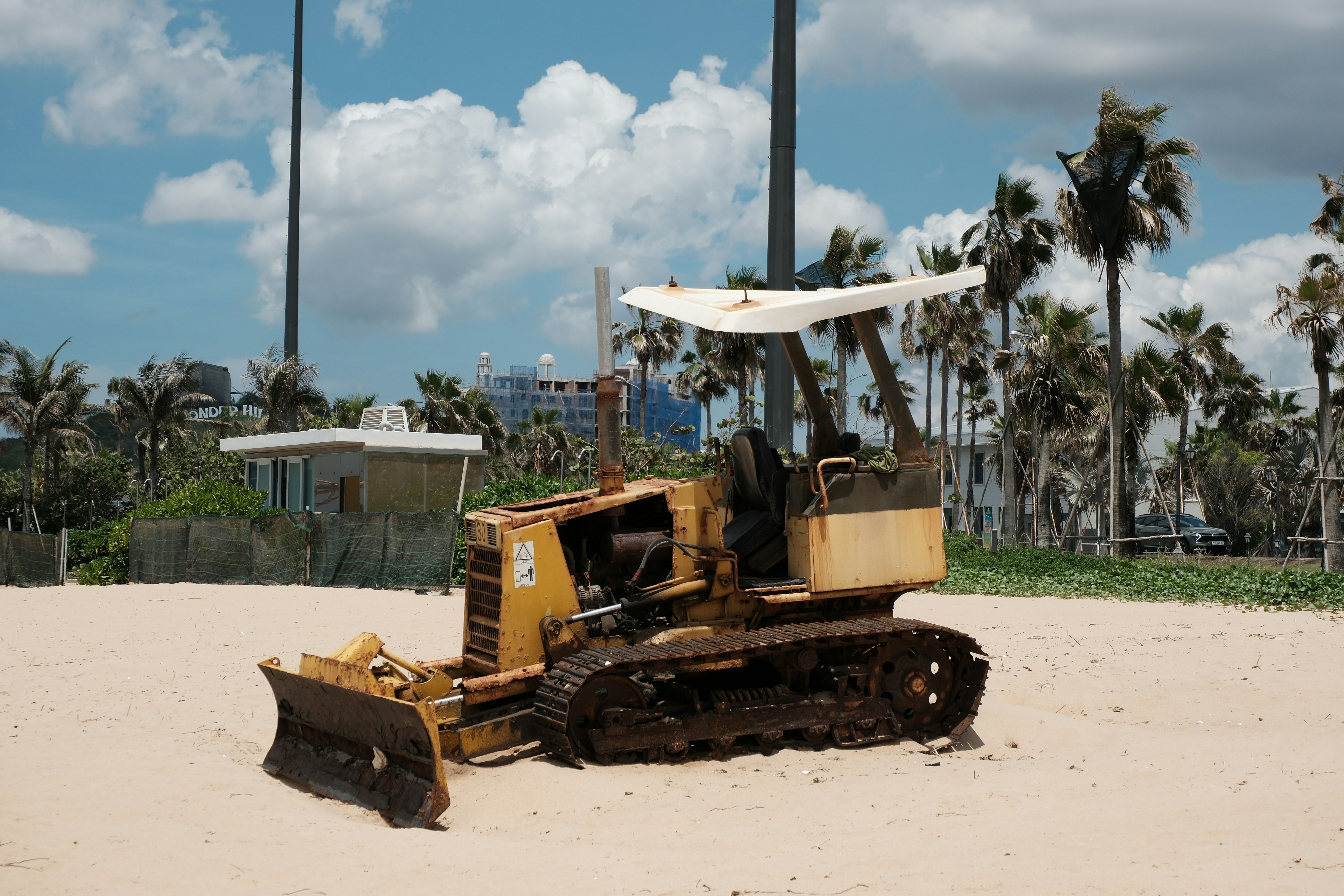 Deserted Workhorse: A rusted bulldozer resting under a warm beach sun