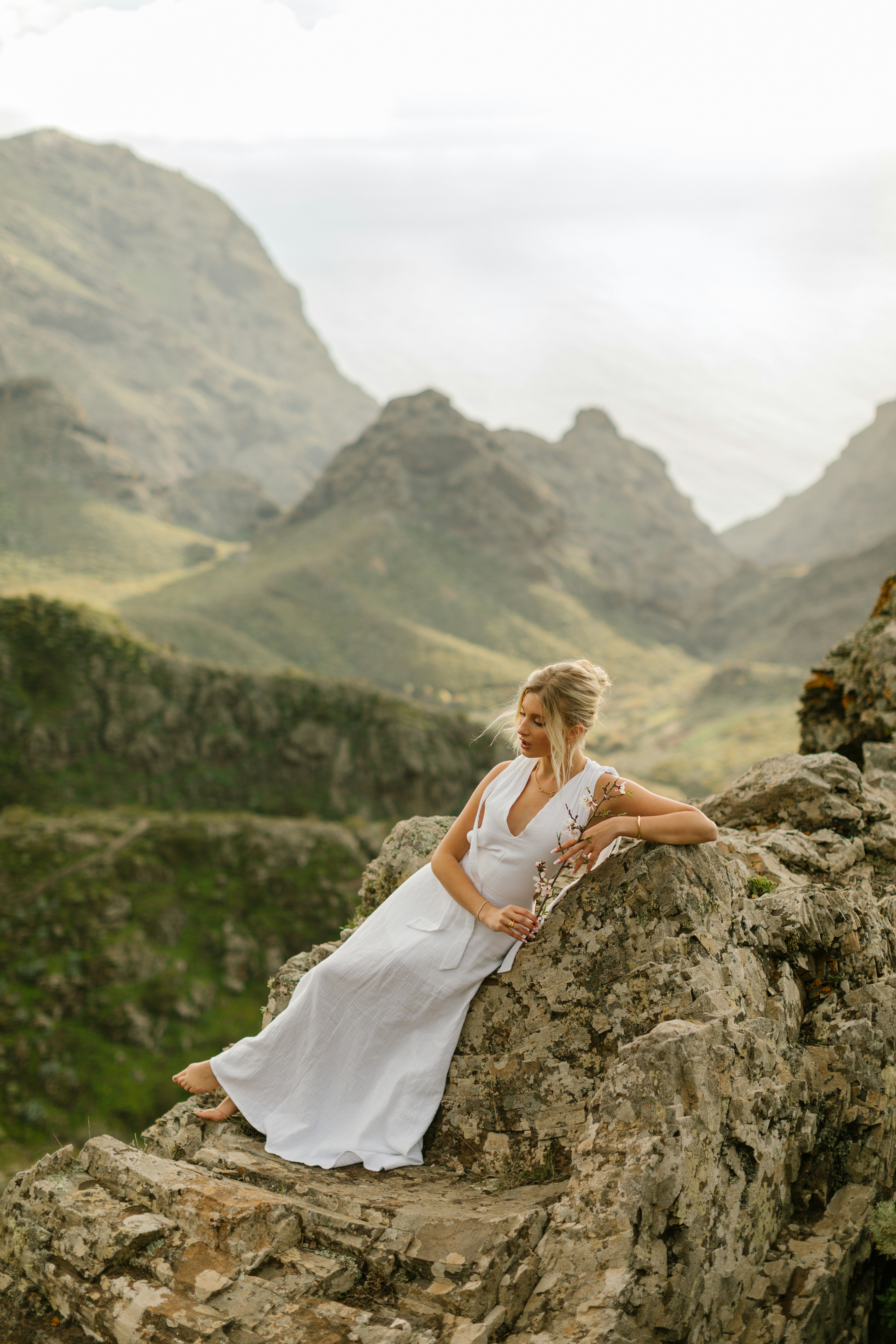 White-dress Quietude: A Woman Reposes on Alpine Rock