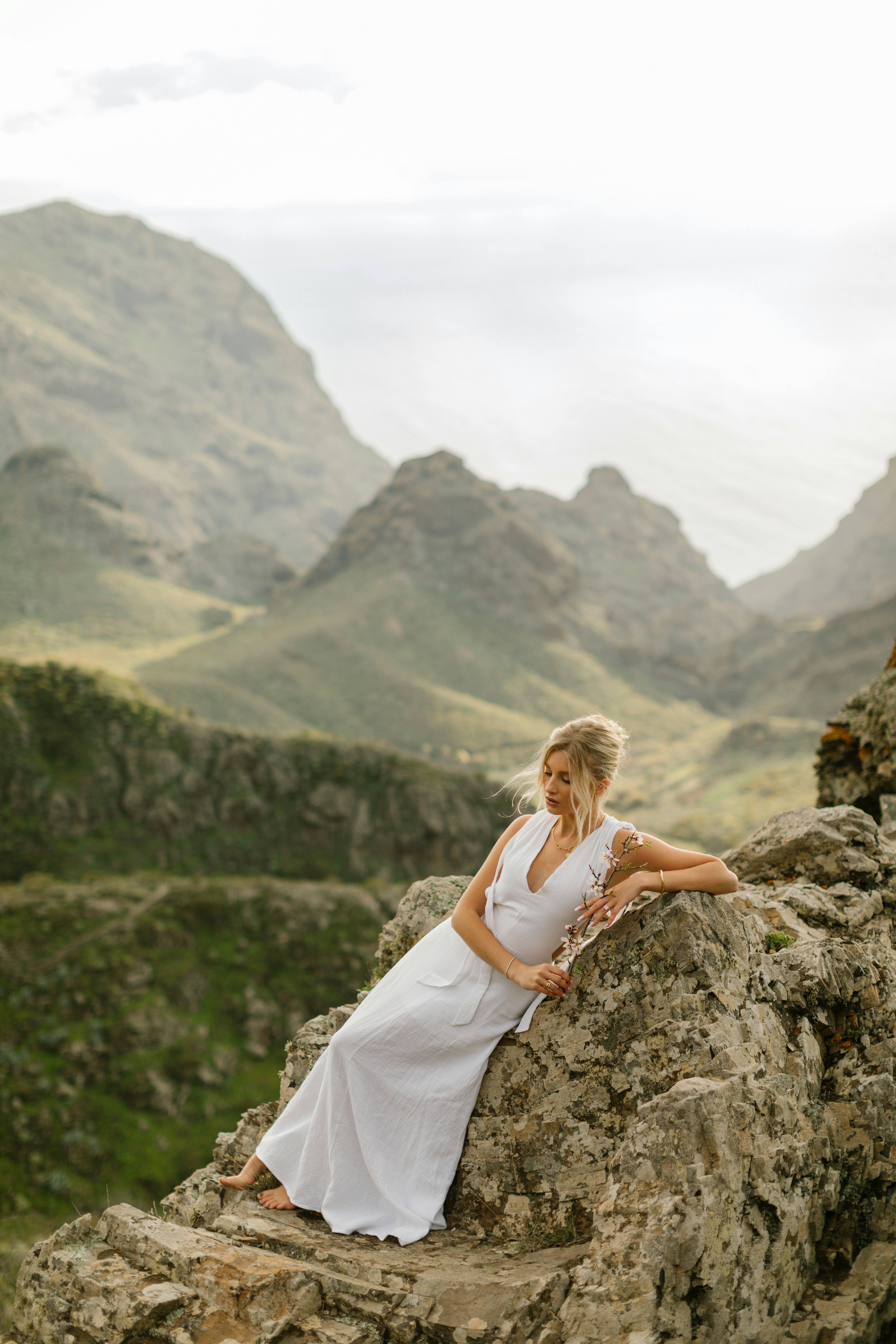 White-dress Portrait amid rugged seaside cliffs at golden hour