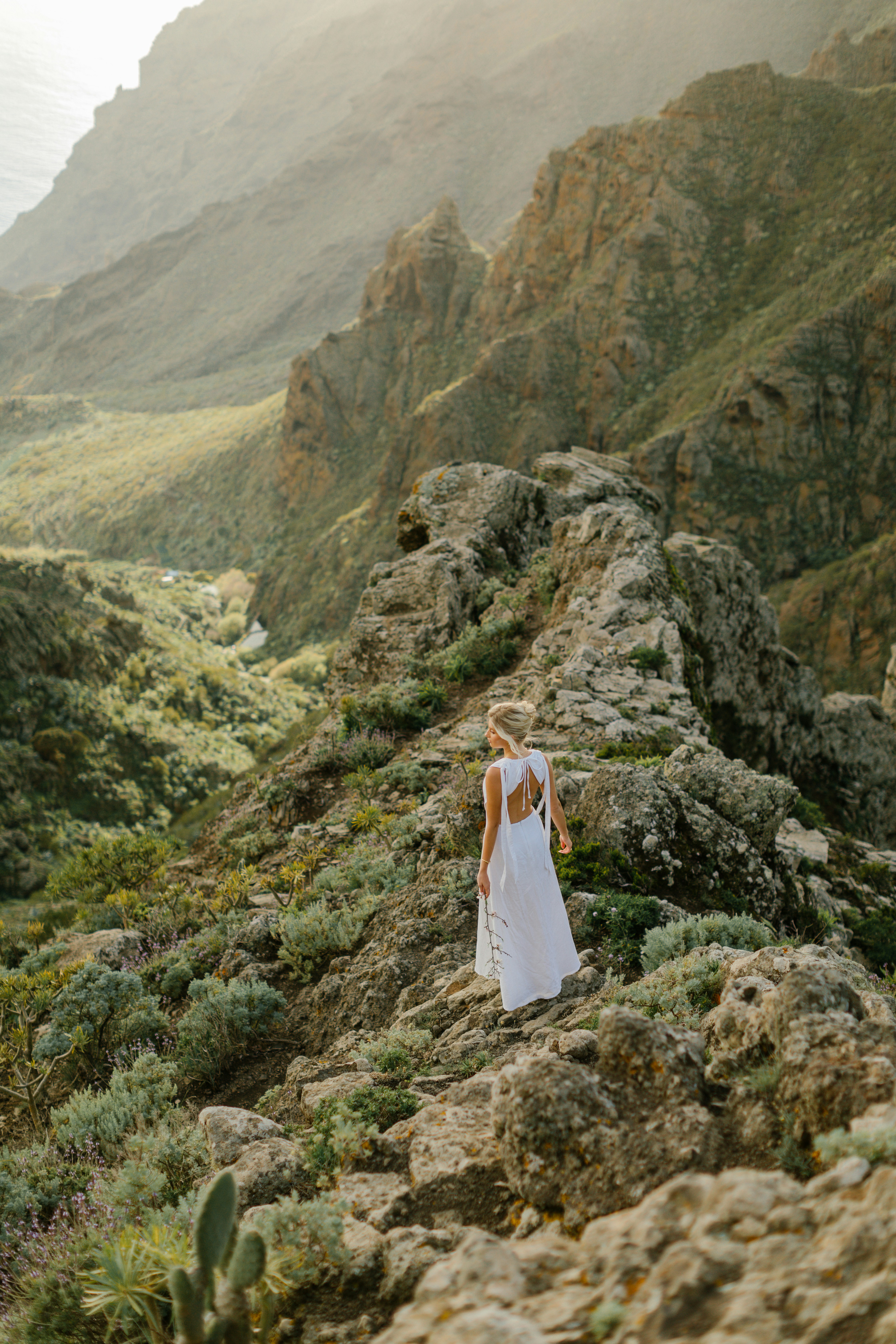 Cliffside Reverie: A Woman in White on the Edge of Aegean Males