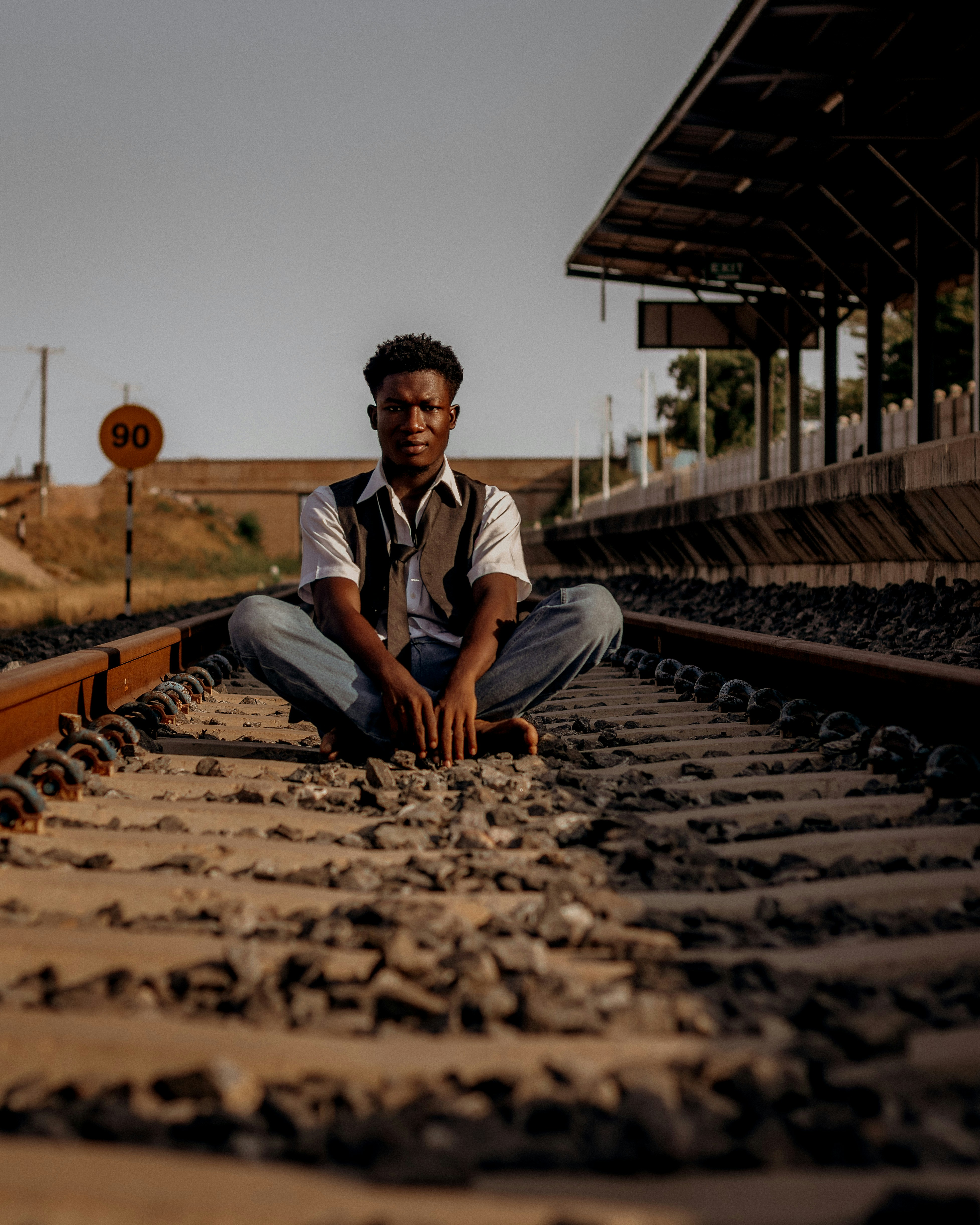 Centered on the Railcar Quiet: a Young Man Meditates Between Rails
