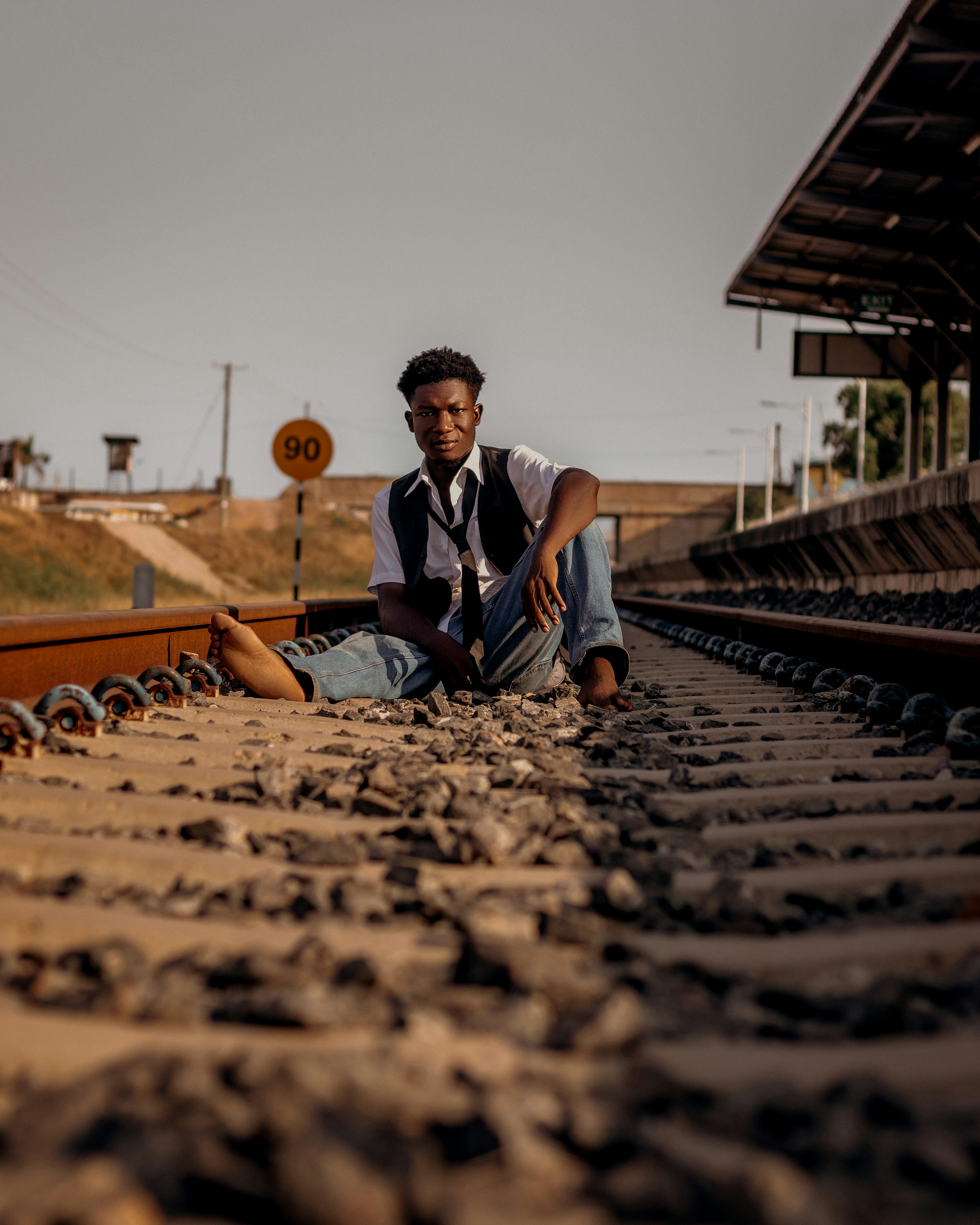 Railway Quiet: Youthful Portrait on Sunlit Tracks