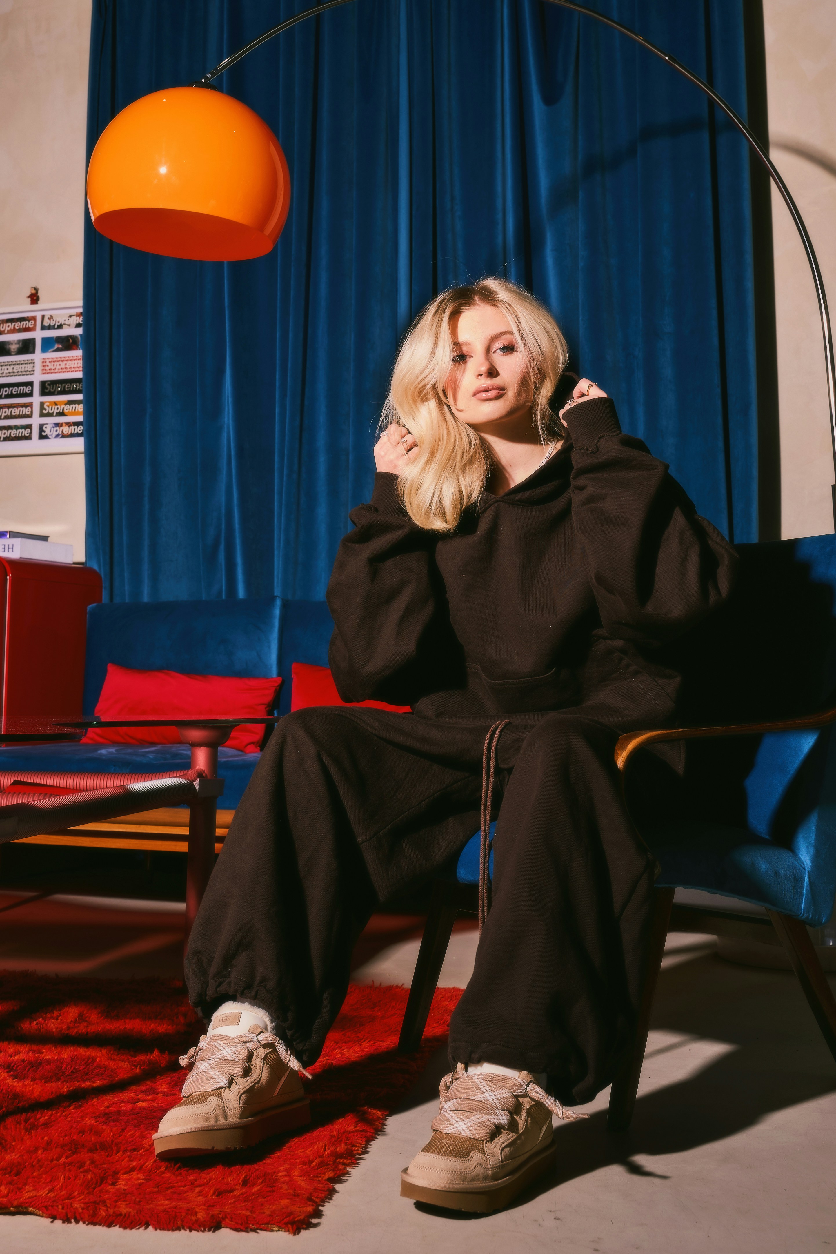 Blonde portrait in a retro lounge under an orange arc lamp
