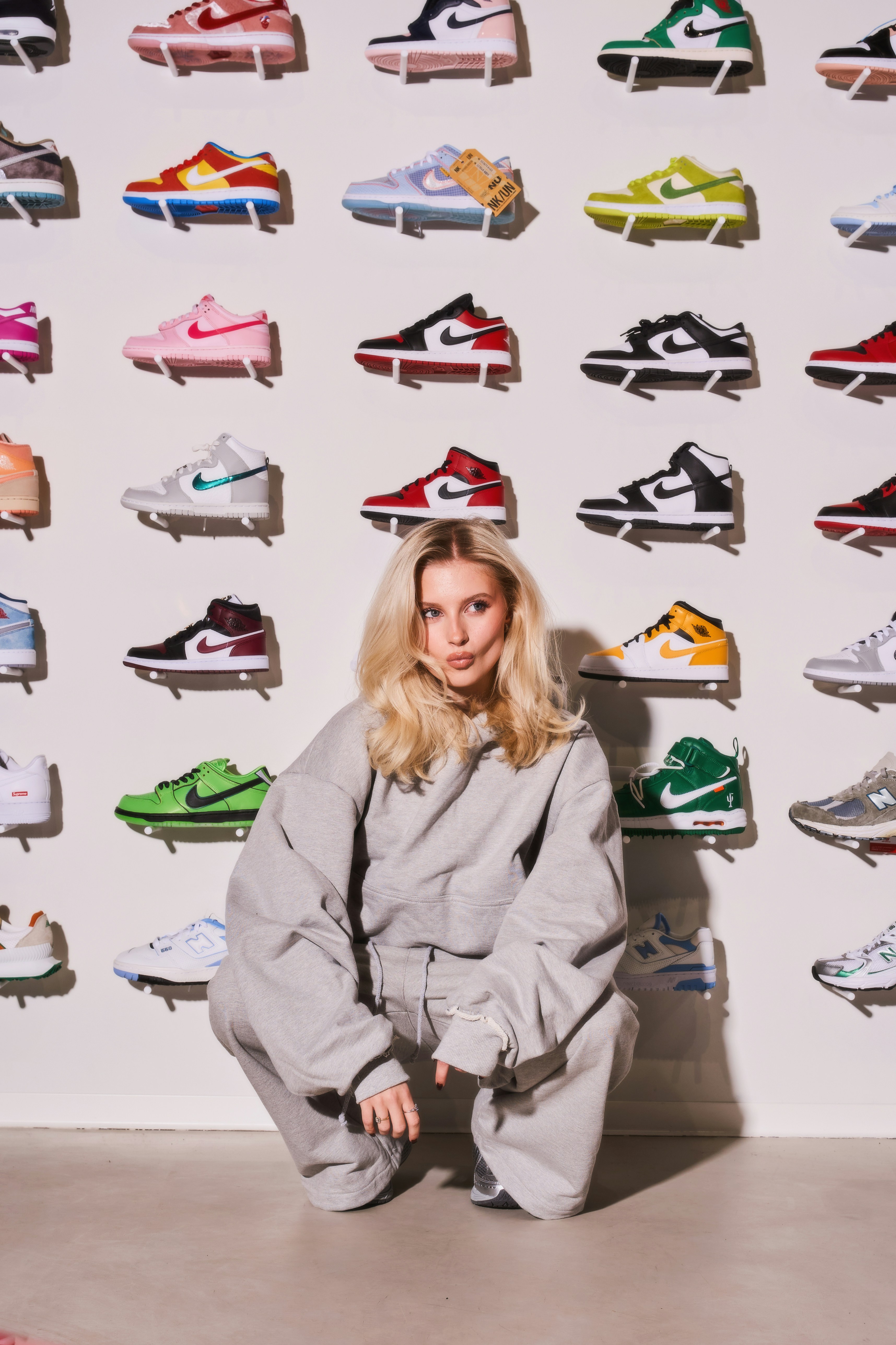 Pose in a Wall of Sneakers: Soft Spotlight on the Quiet Confidence