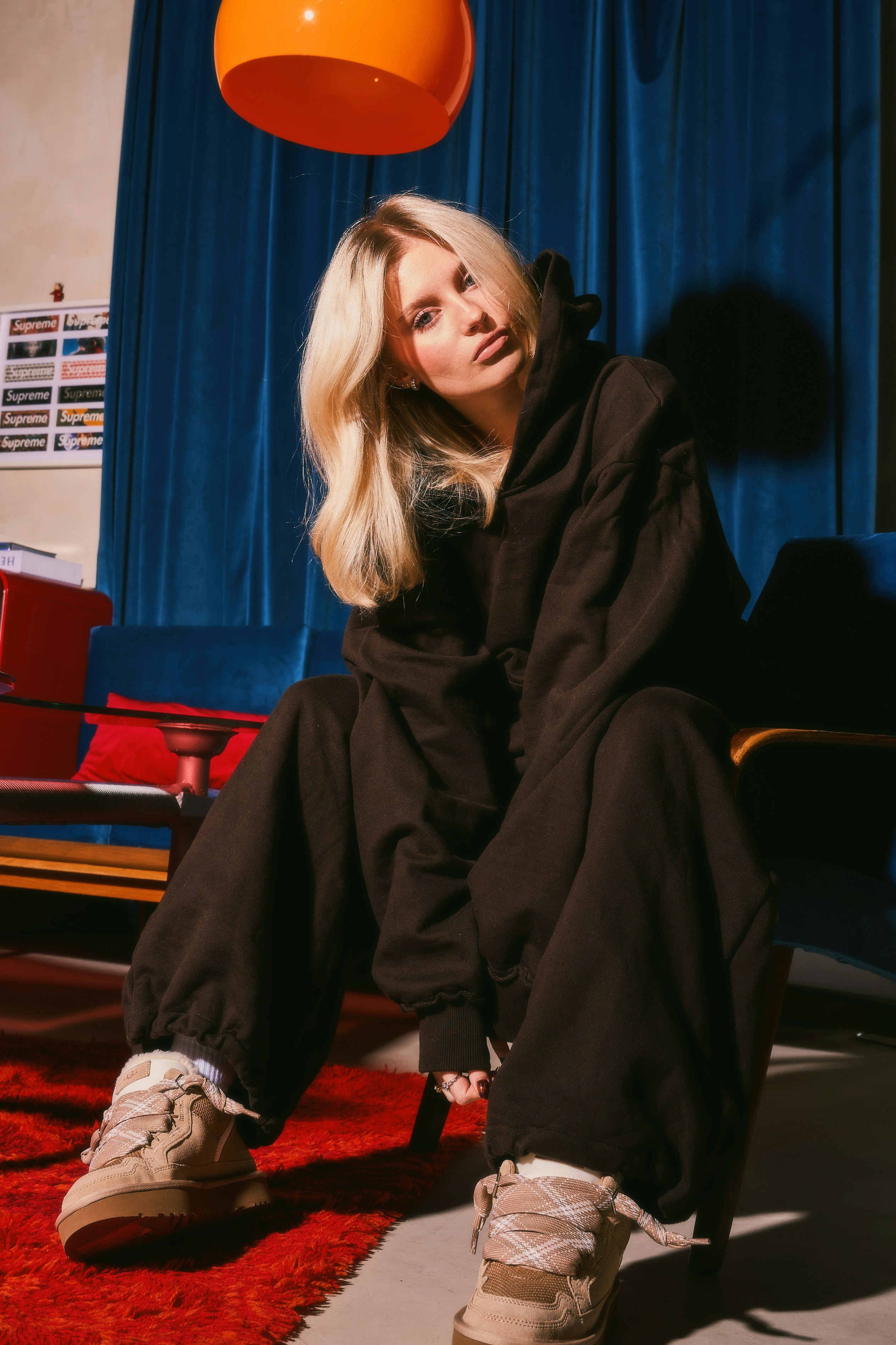 Blonde in a Dark Hoodie: Quiet Confidence in a Retro Lounge
