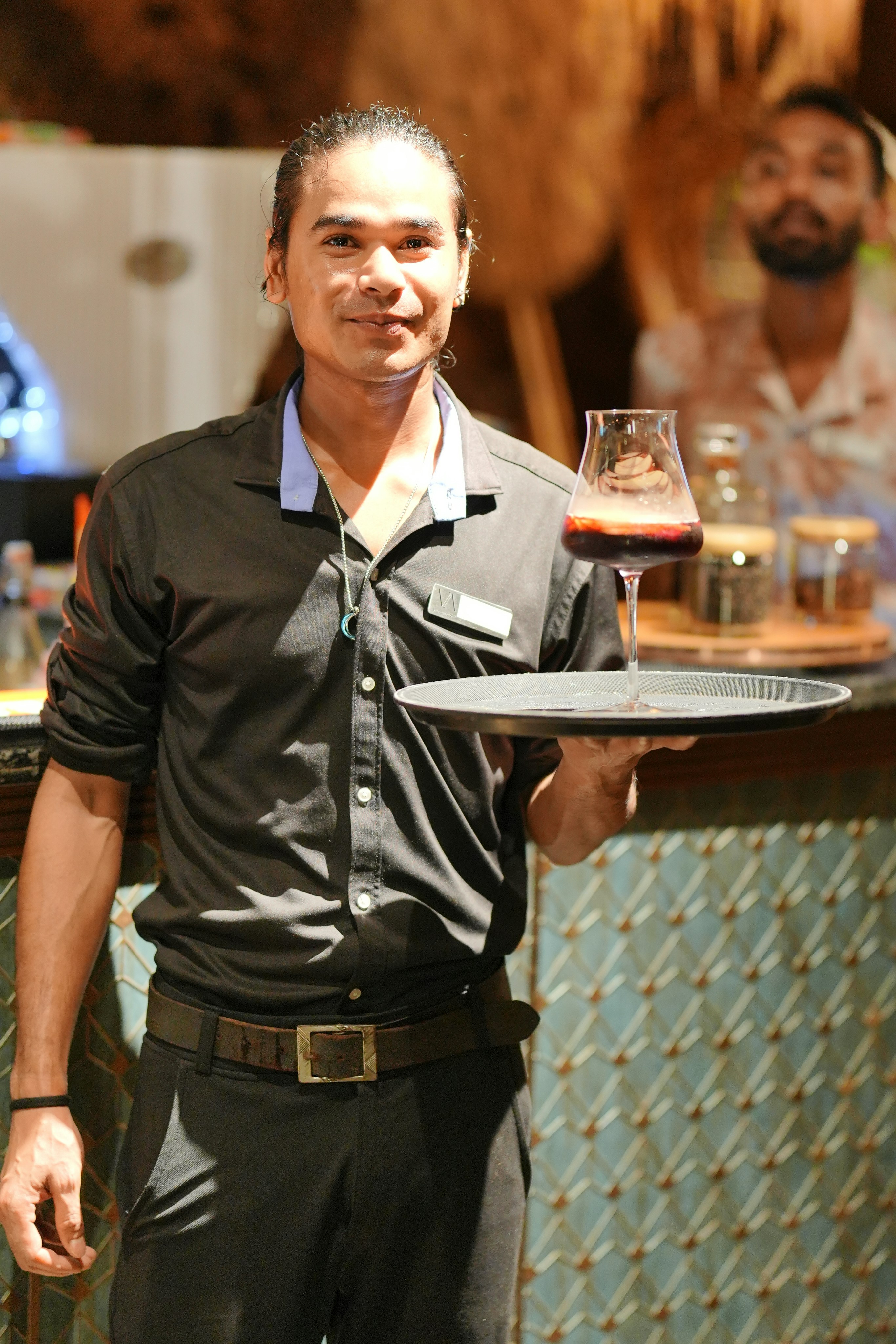 Waiter with a Glass of Red at a Cozy Bar