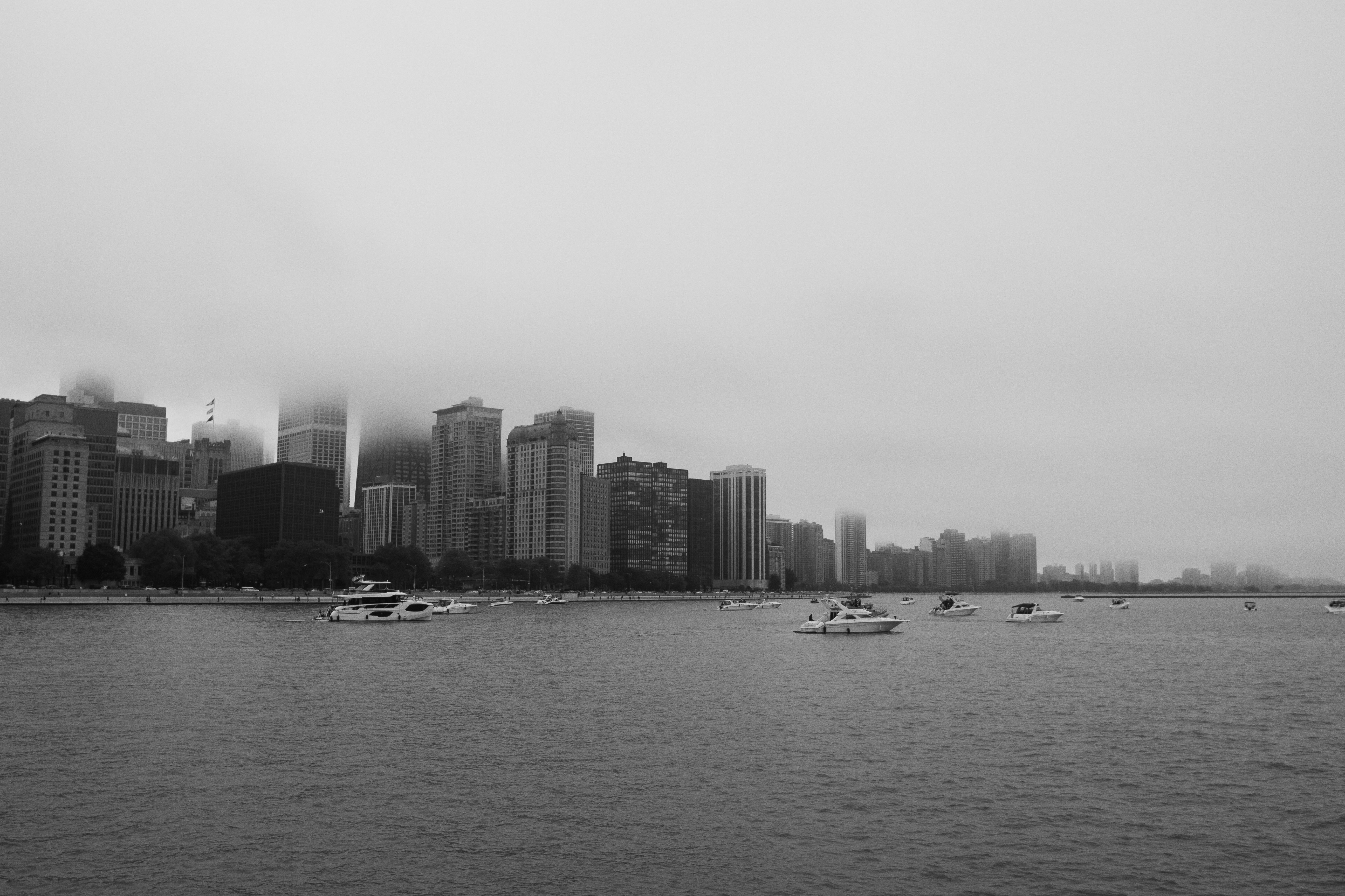 Mist over the Marina: City Silhouette and Boats on Calm Waters