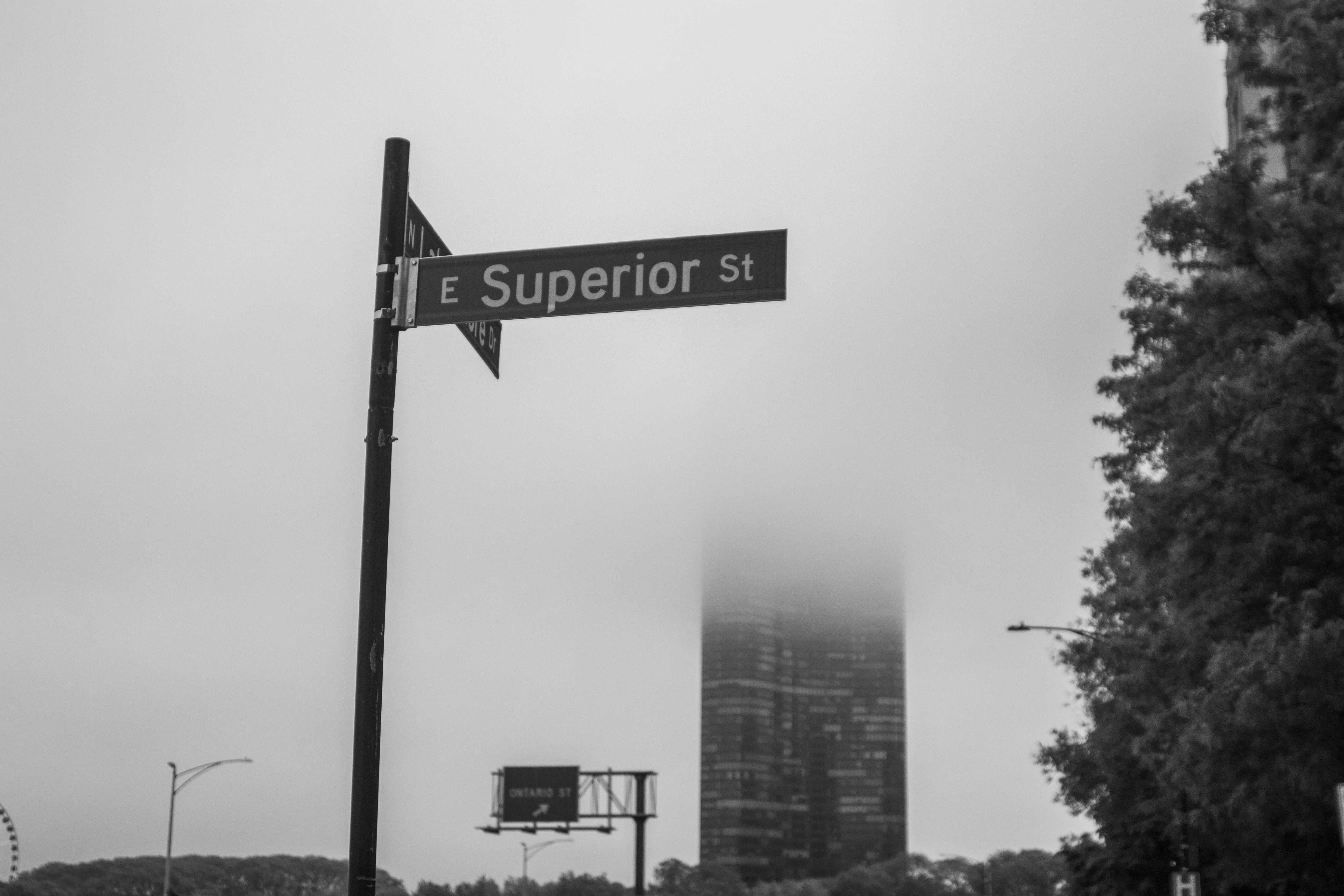 Fogged Corner: Street Sign Meets Tower in Quiet Monochrome