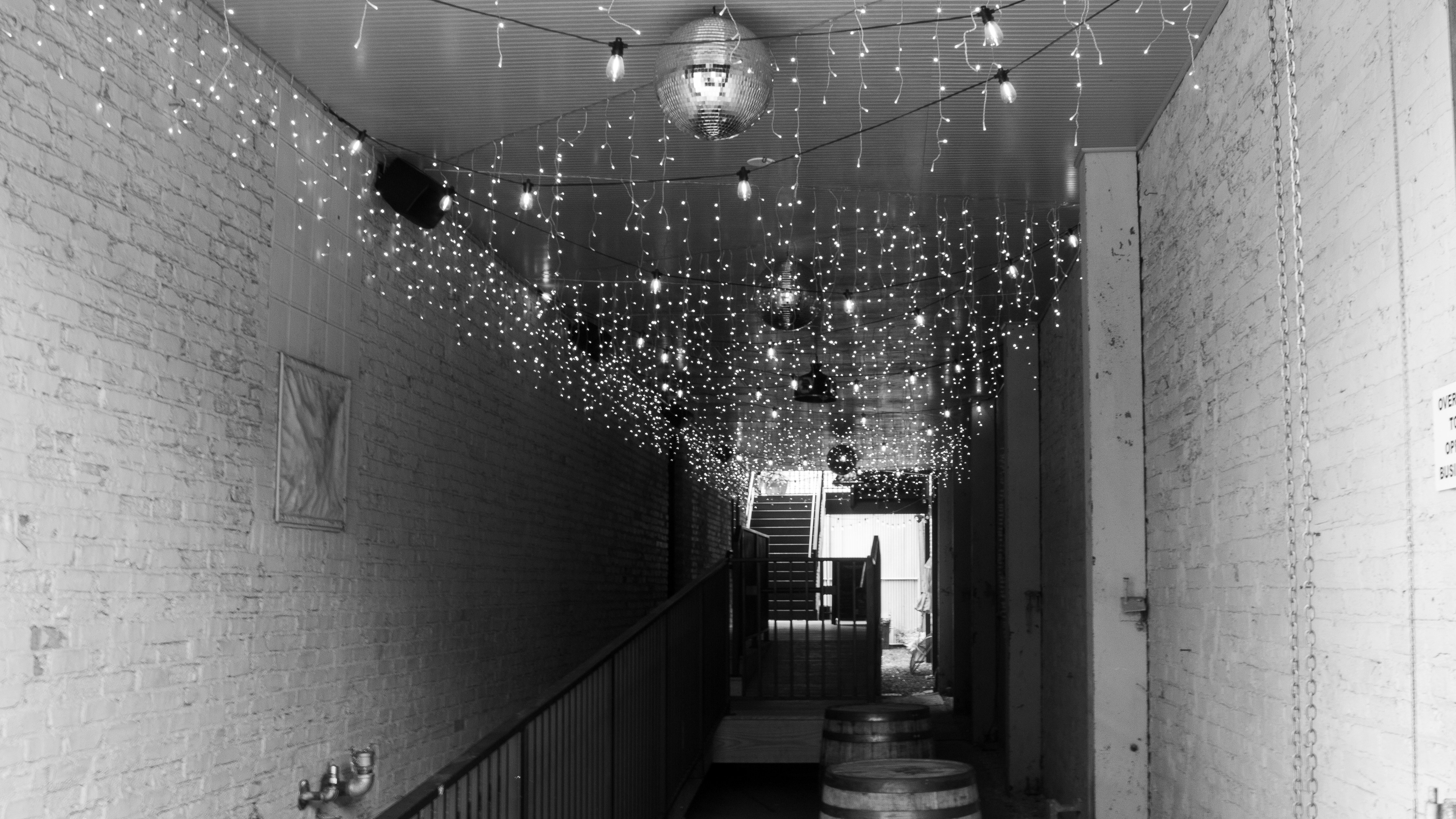A string of lights guiding an urban alleyway toward a distant glow