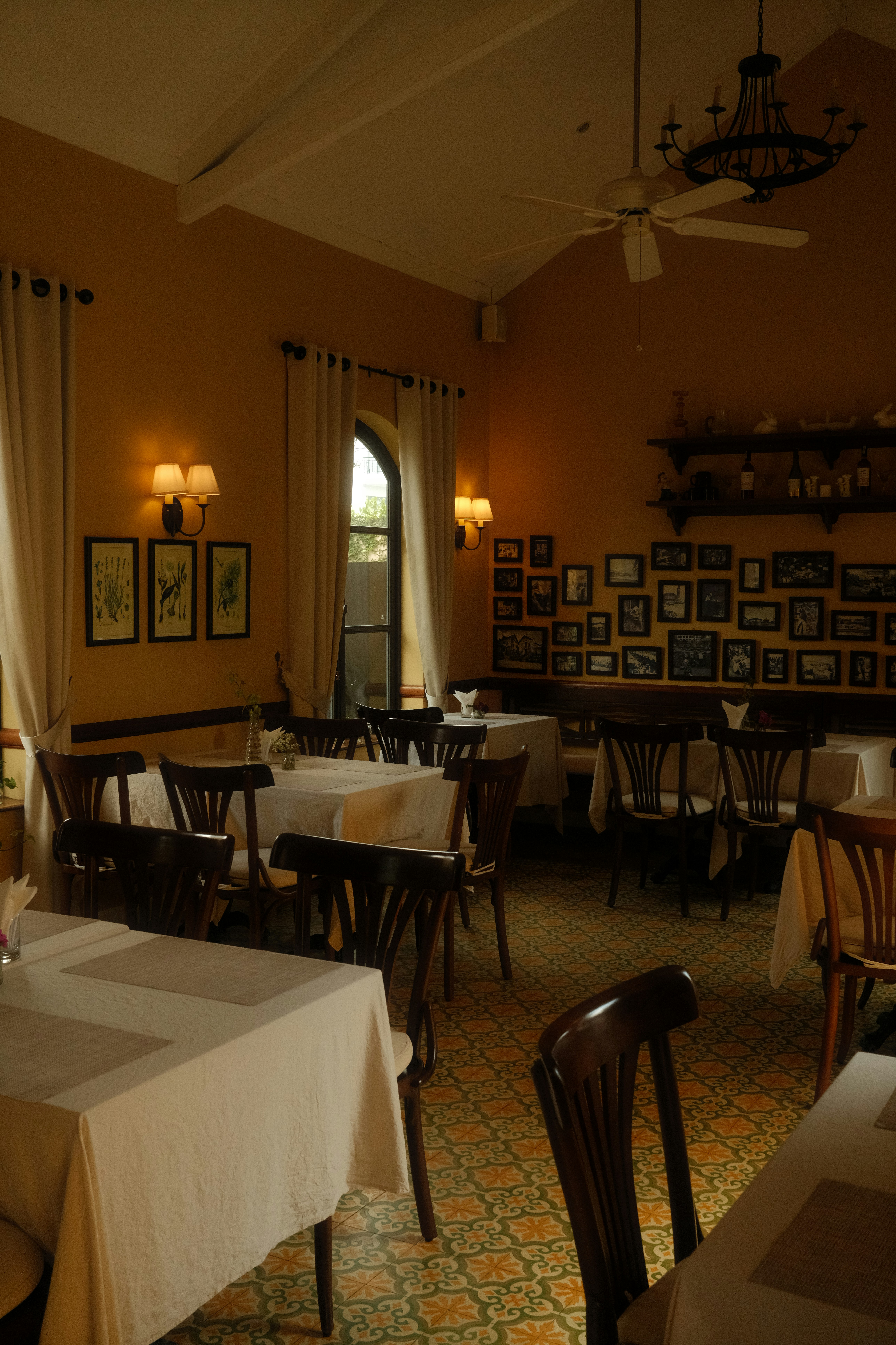 Dimly Lit Bistro Hall with Portrait Wall and White-Table Dining