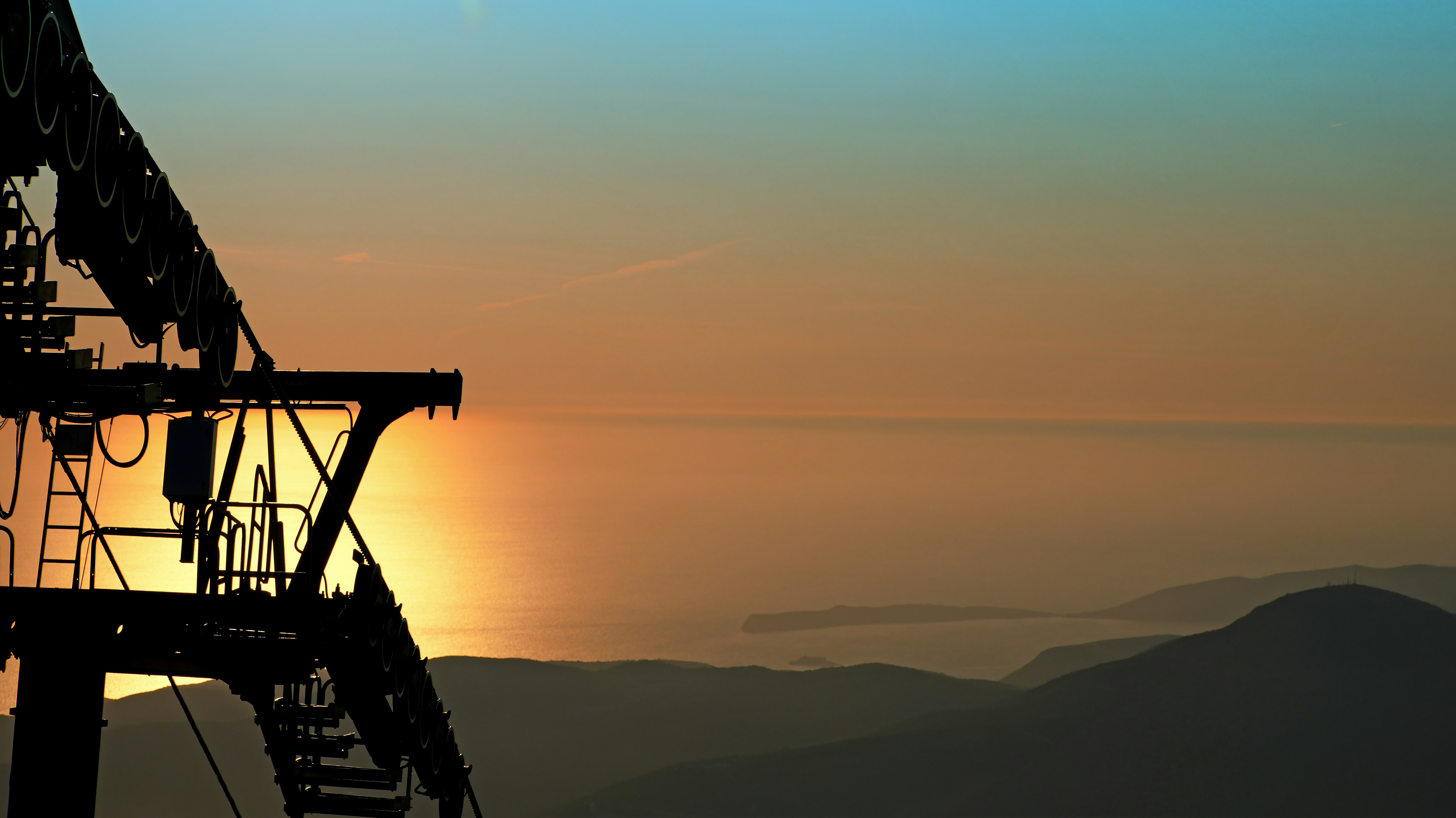 Silhouette of a Cable Structure Framing a Golden Horizon