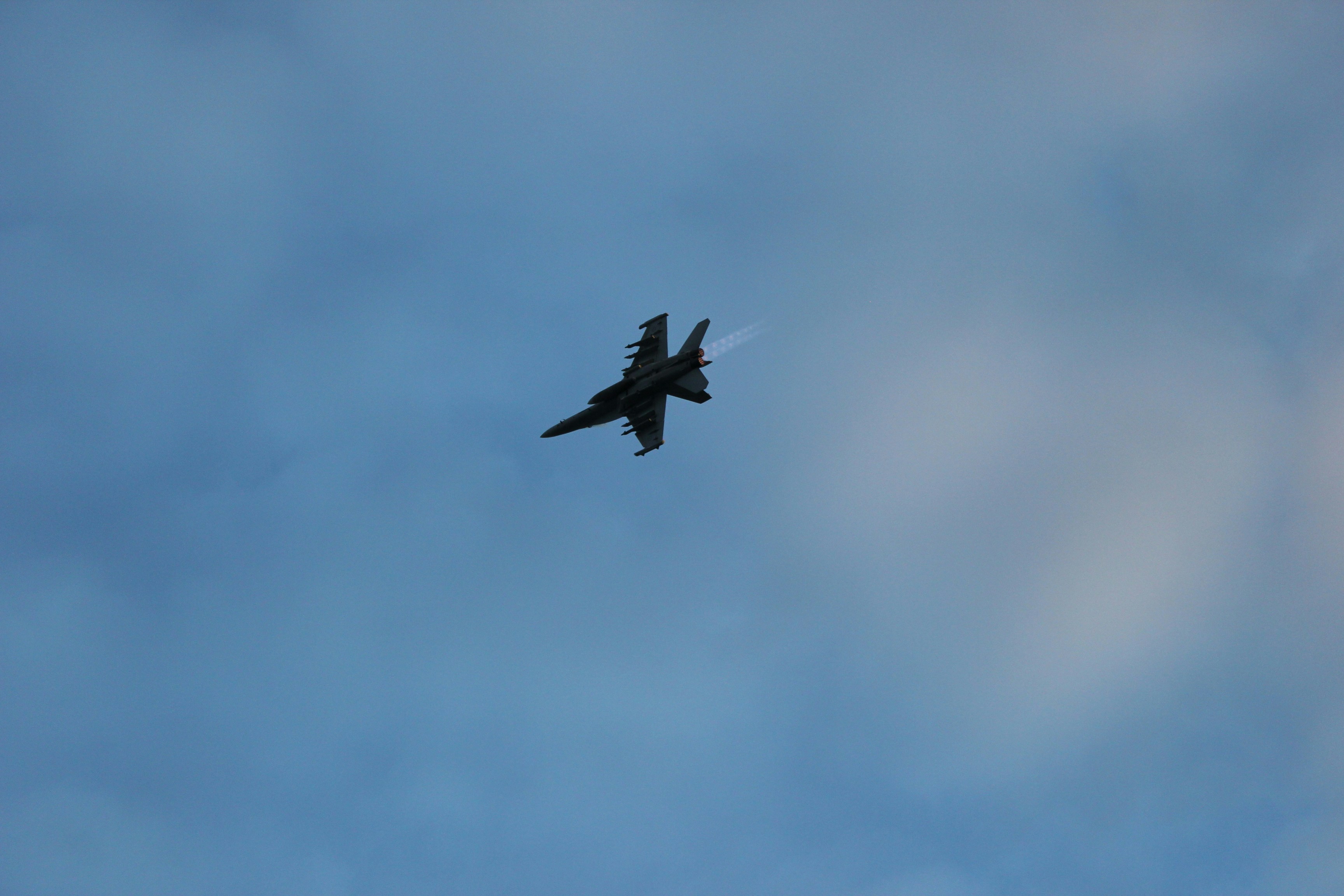 Sky Dominance: A Fighter Jet Skims Across a Blue Wake