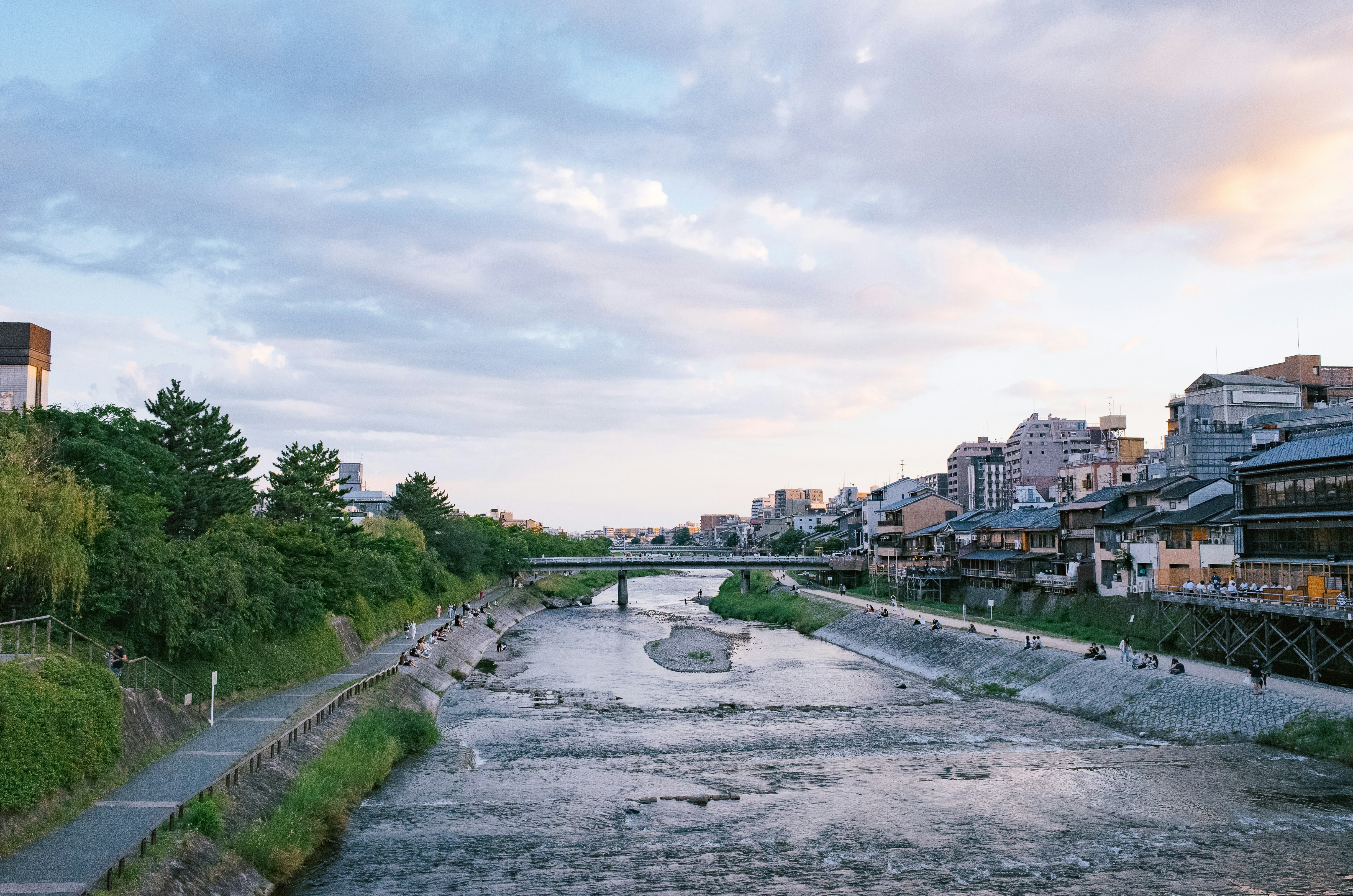Urban Riverwalk at Dusk: Bridges, Water, and Buildings