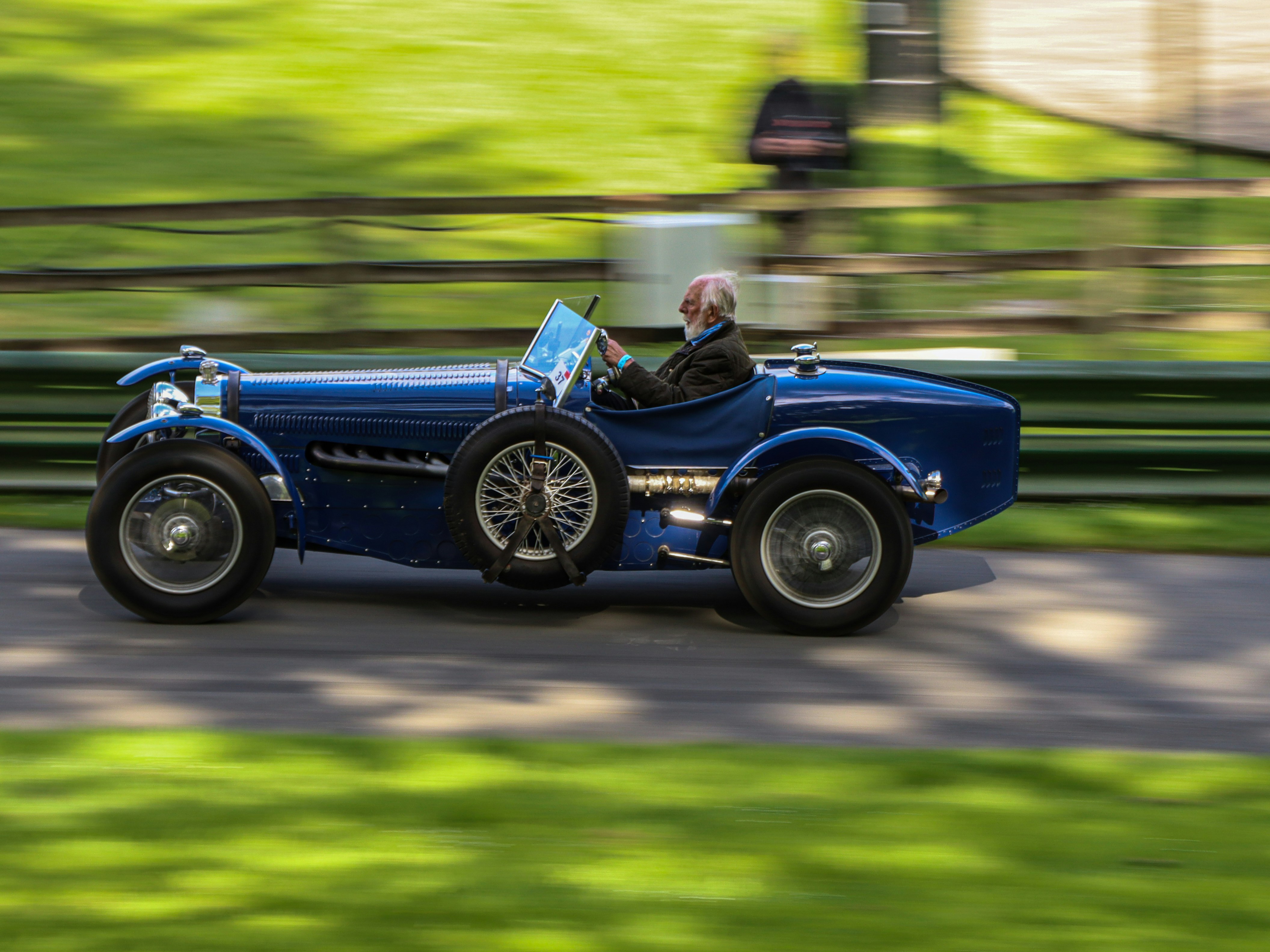 Blue Vintage Convertible in Motion on a Sunlit Lane