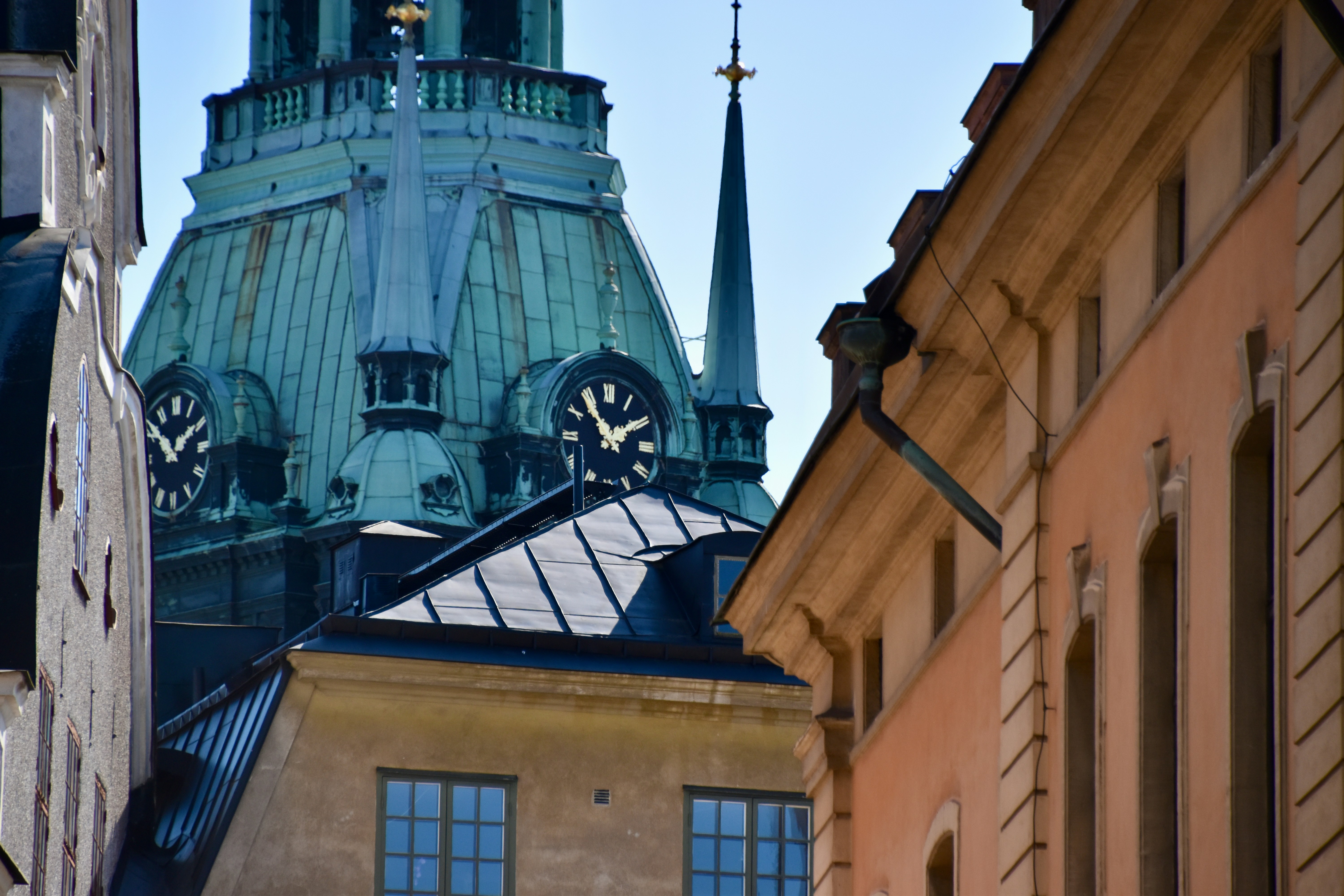 Clock Tower Silhouette: A Sunlit Corridor Between Historic Facades
