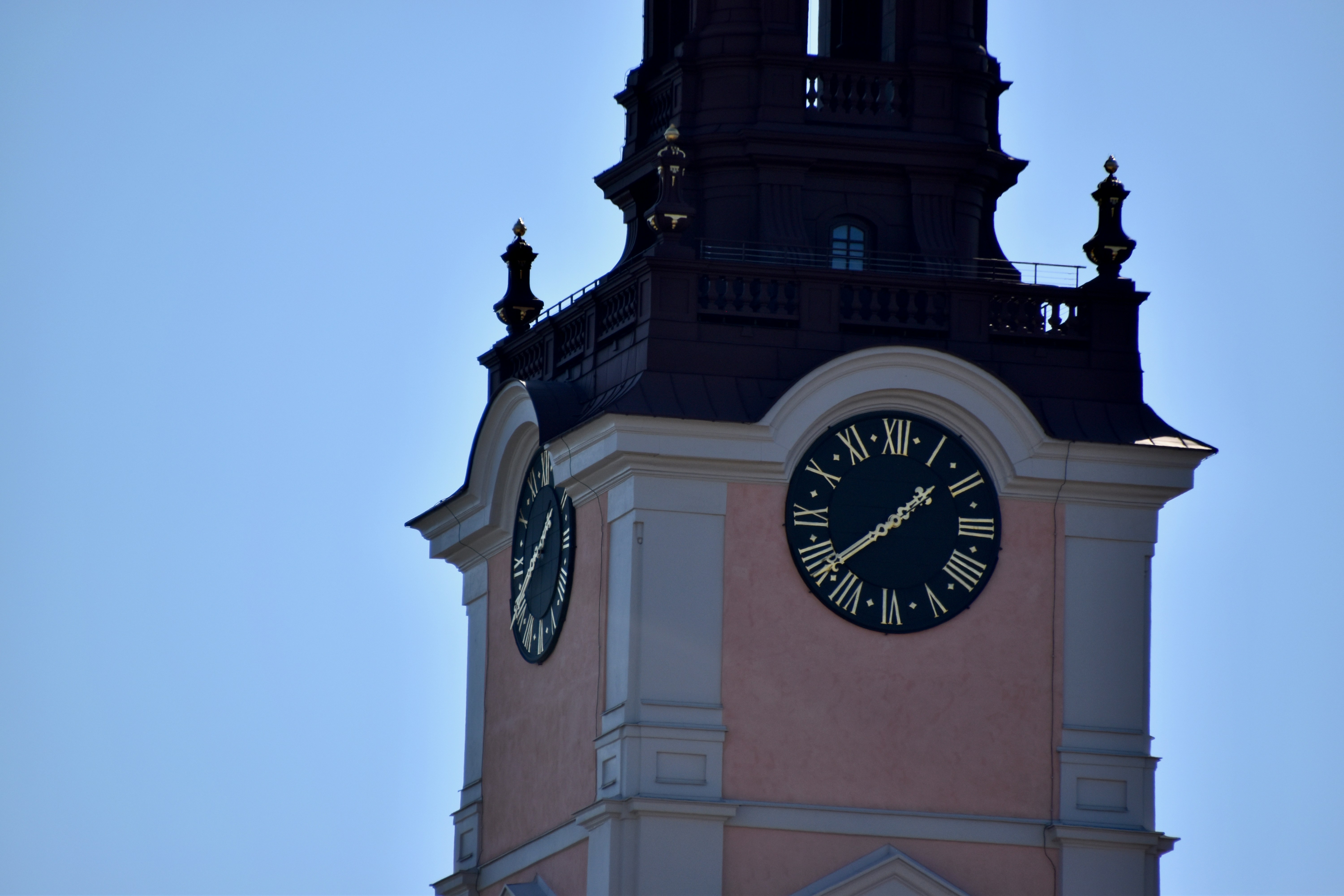 Clocktower Corner: A Pale Pink Facade Under a Clear Blue Sky