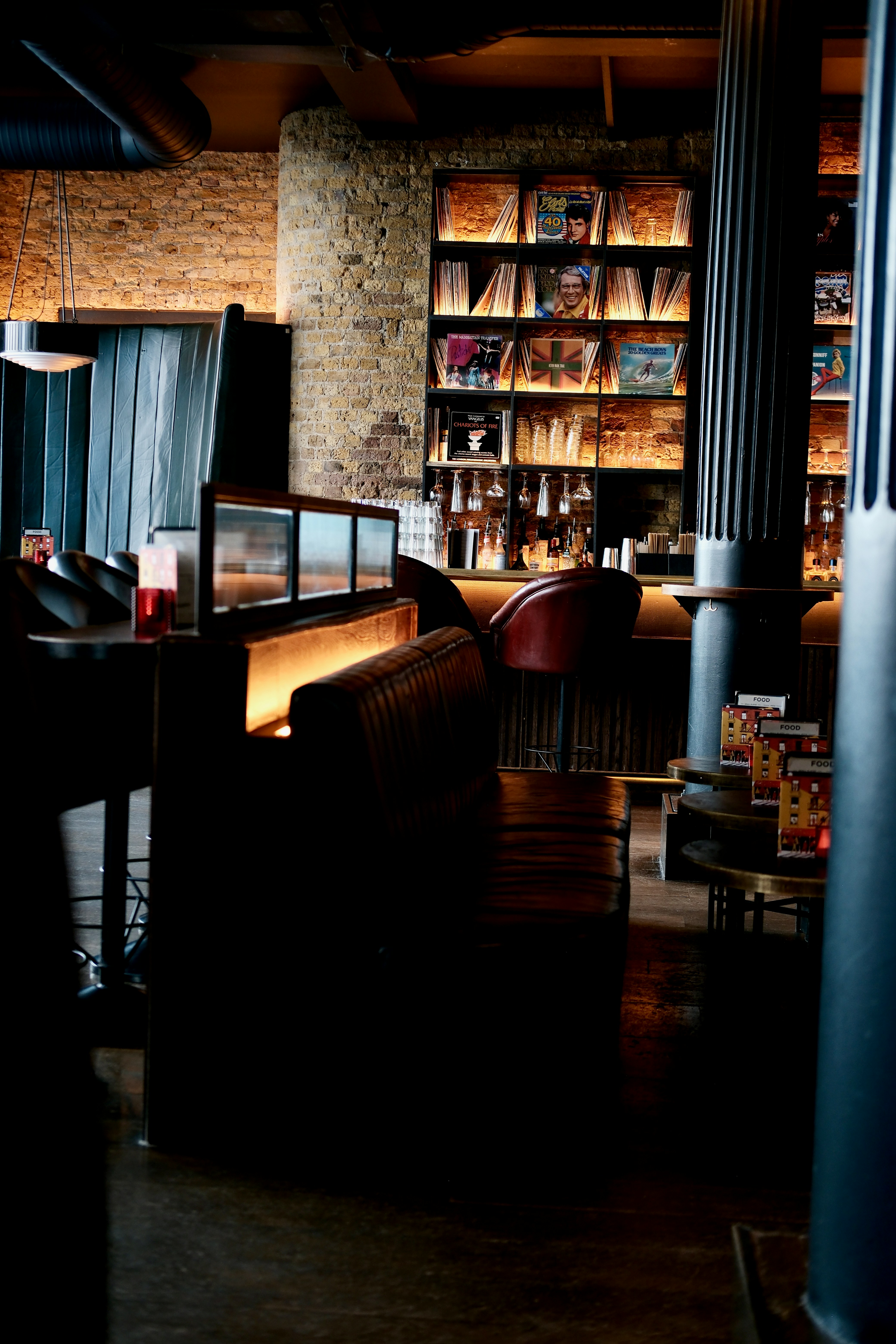 Amber Glow Over Quiet Bookshelves in a Loft Bar