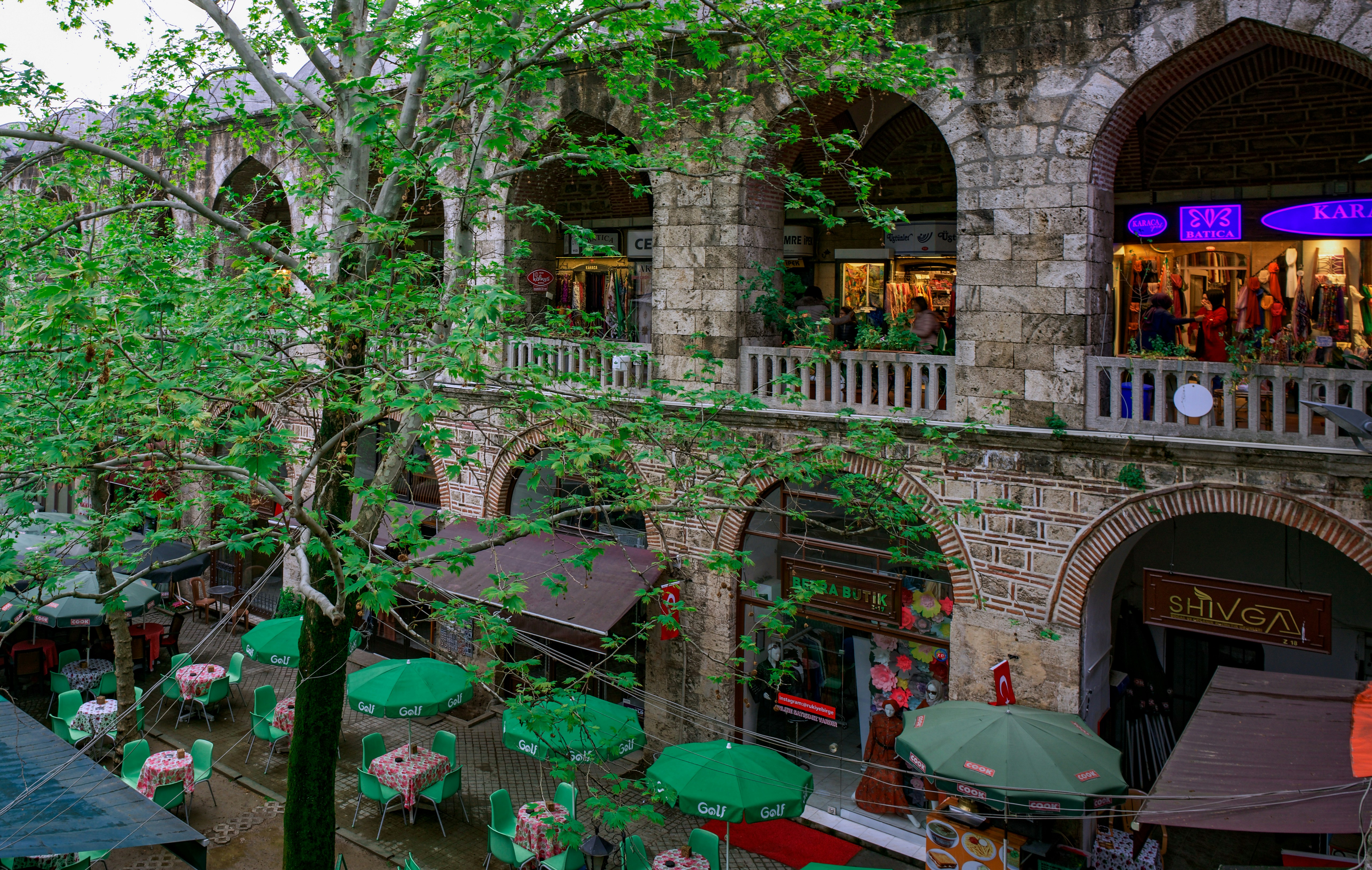 City Courtyard in Stone Arches: Green Canopies and Terrace Tables