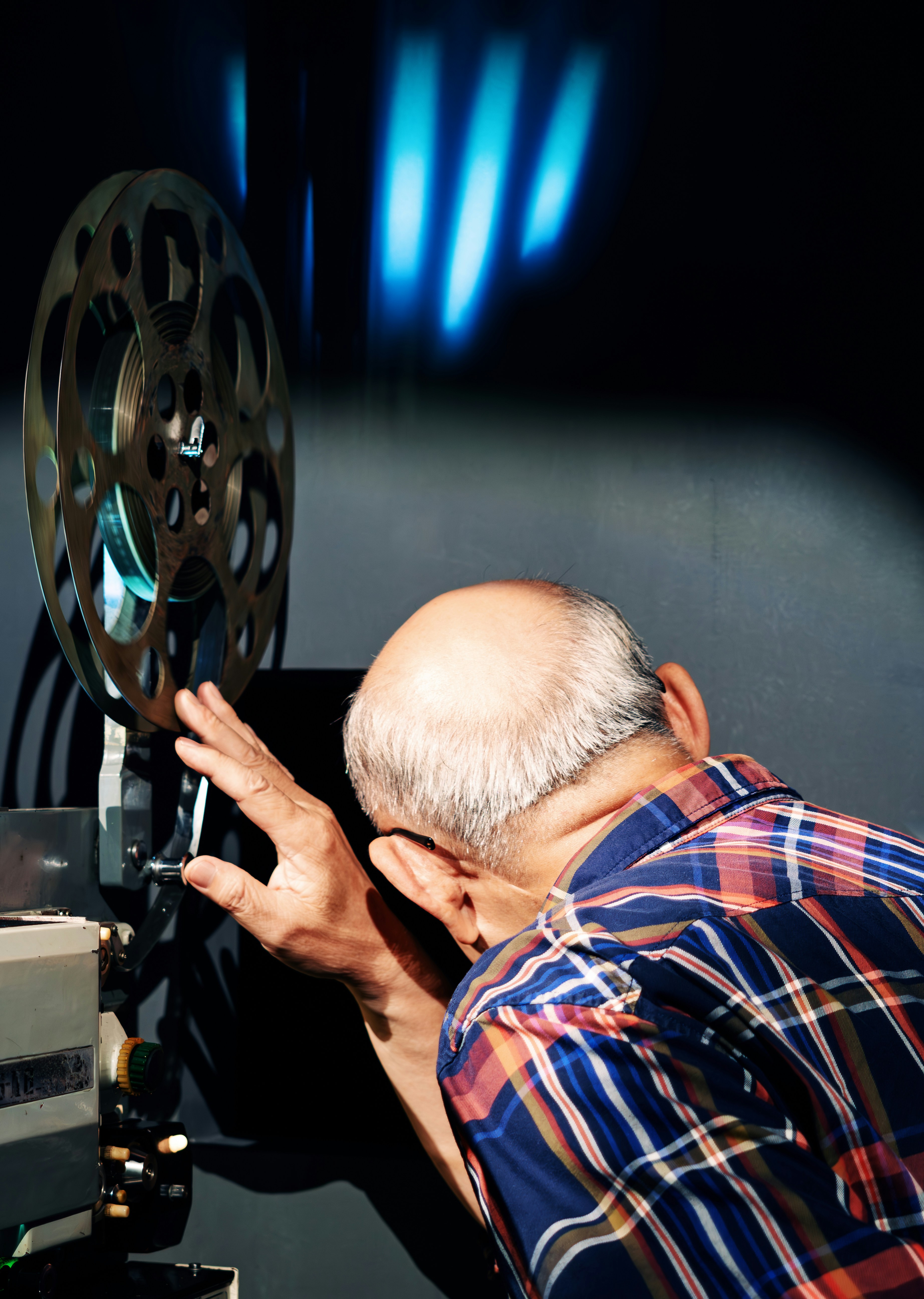 Gleaming Reel: A Technician at Work with a Classic Film Projector
