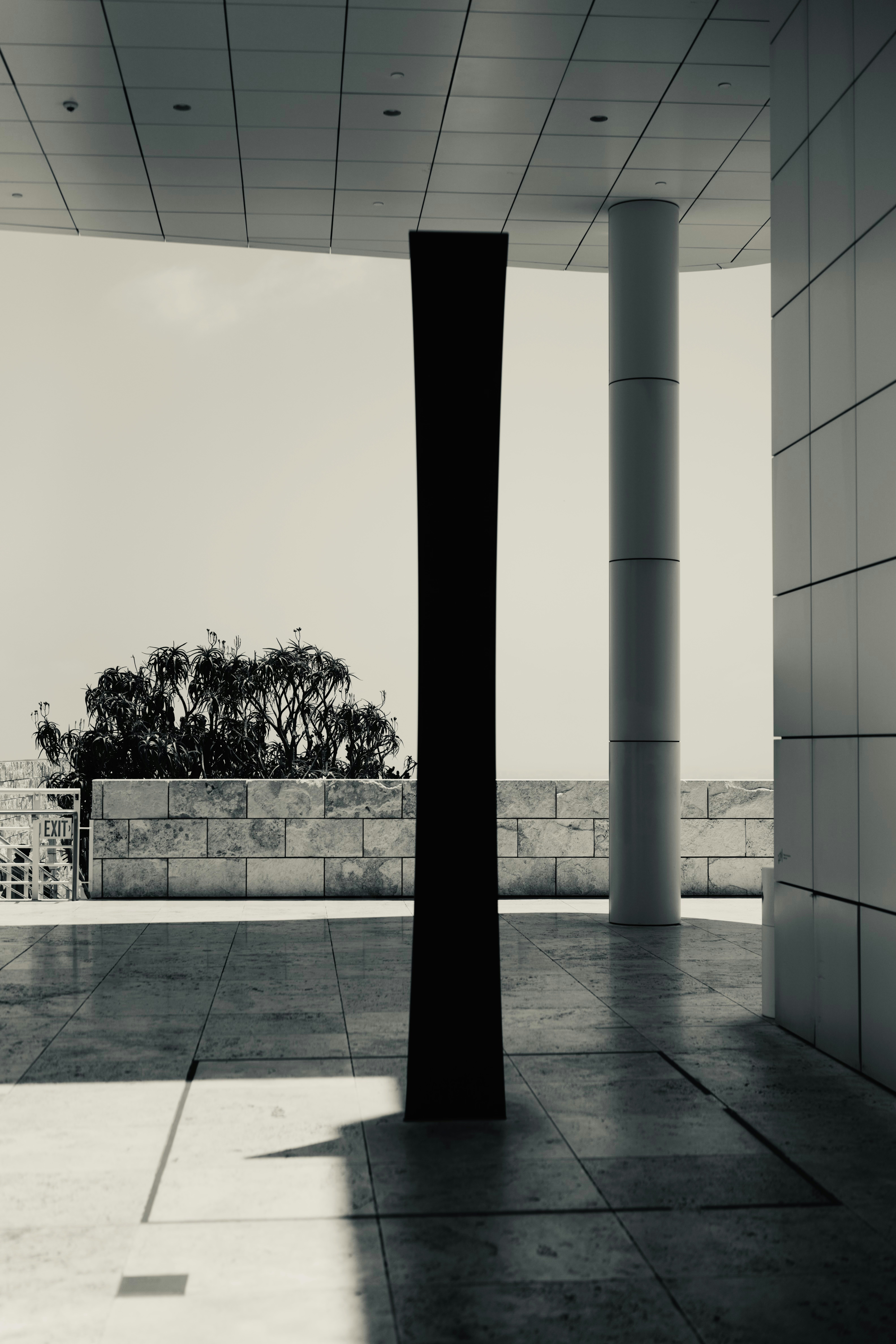 Shadowed Pillar Amid Fixed Architecture
