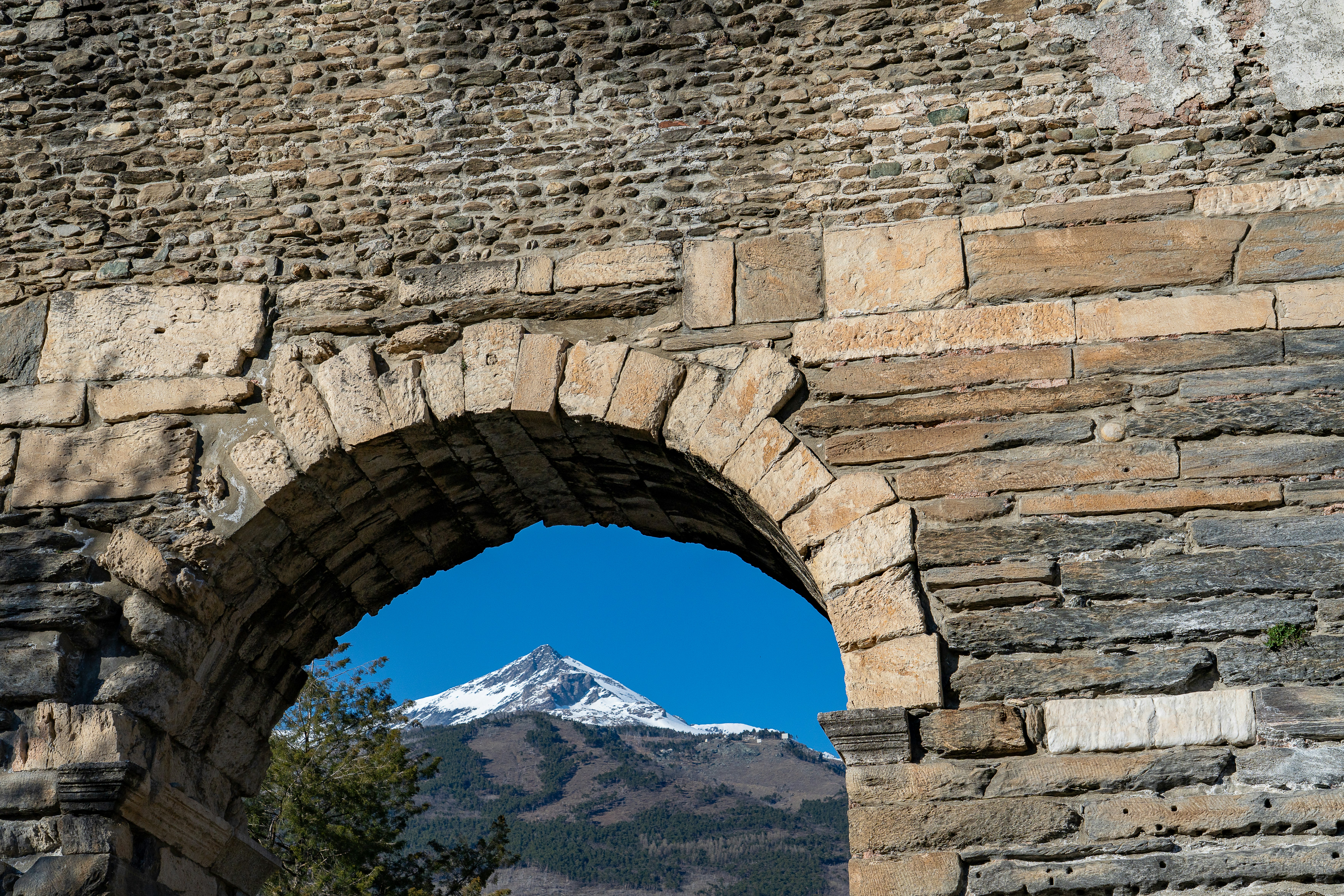 Mid-Arch View: Snow-Capped Peak Framed by Ancient Stones