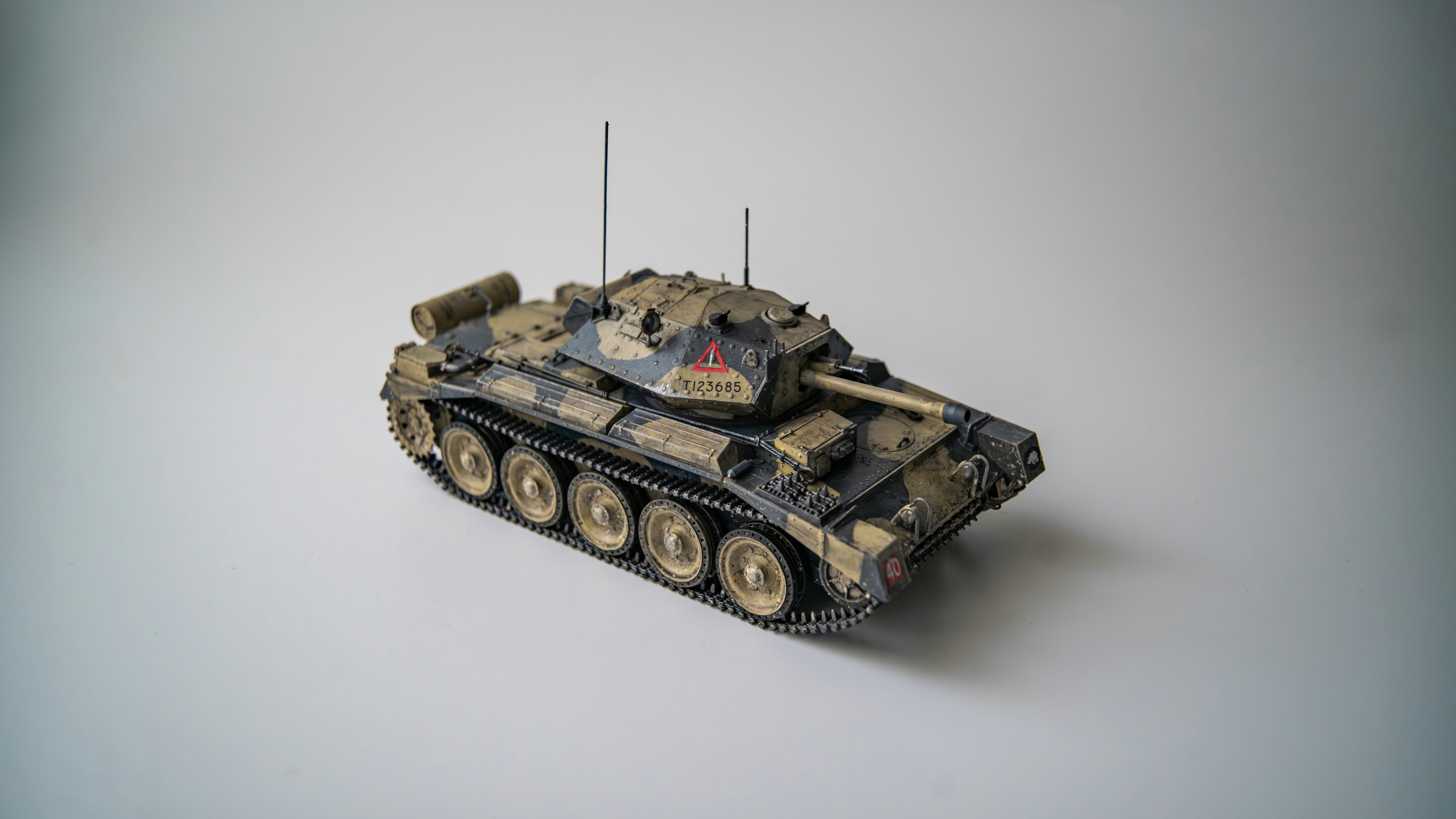 Scale Sentinel: A Detail Shot of a Model Tank on Pale Slate