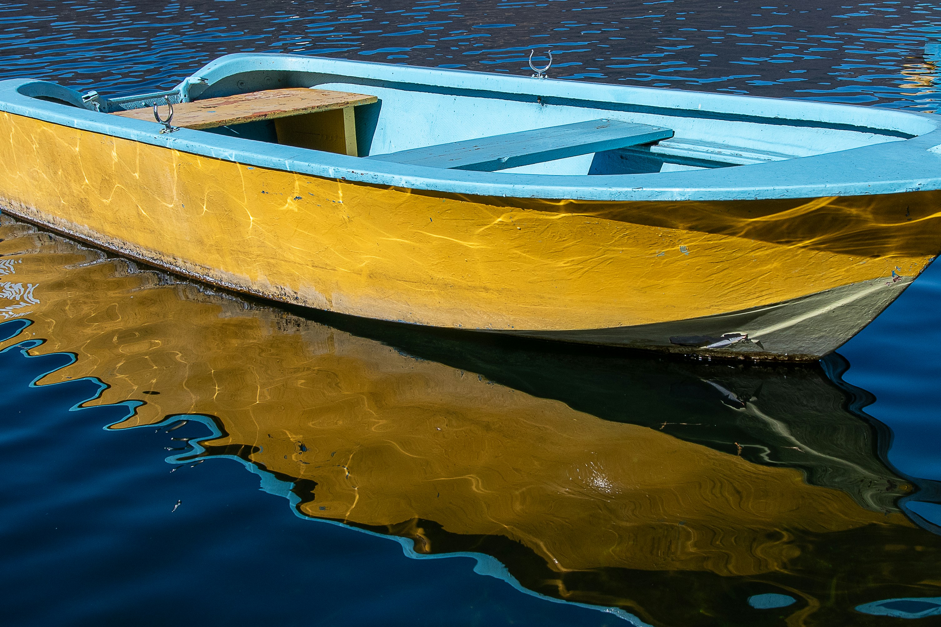 Sunlit Boats, Quiet Waters: A Reflective Duo of Blue and Gold