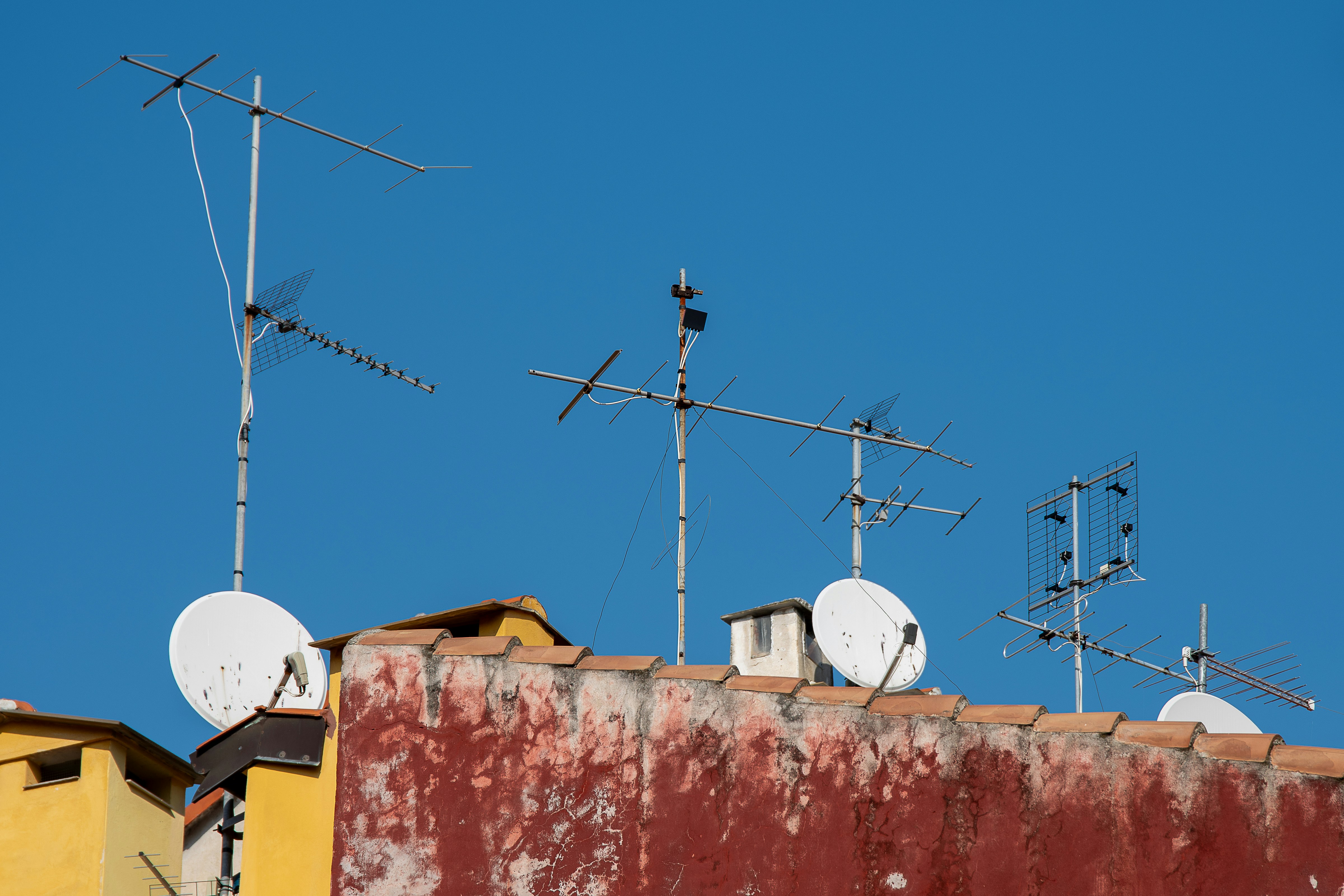 Rooftop Antenna Ballet Under a Clear Blue Sky