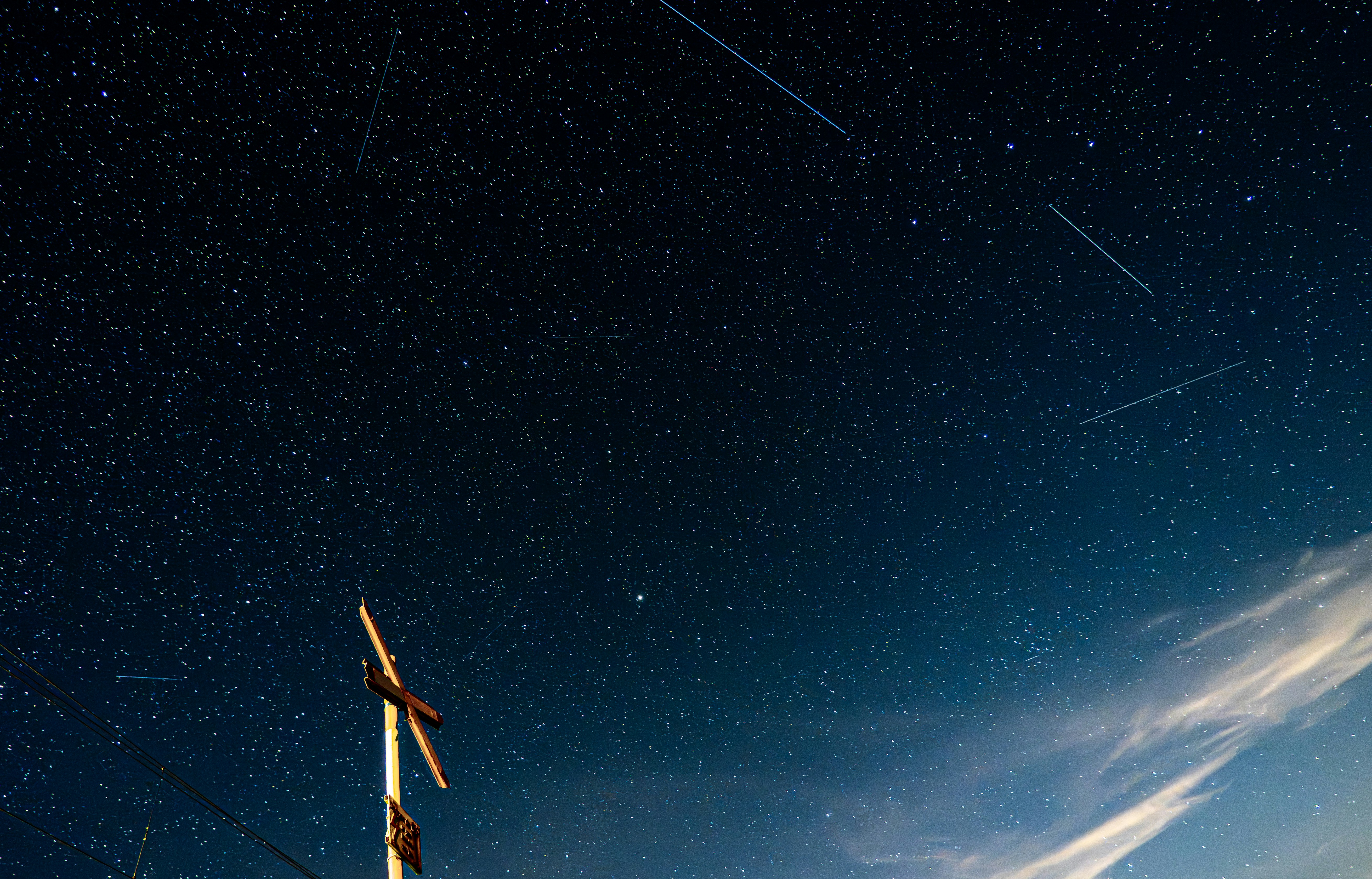 Stargazer's Silhouette: A Night Sky Trail of Meteor Streaks