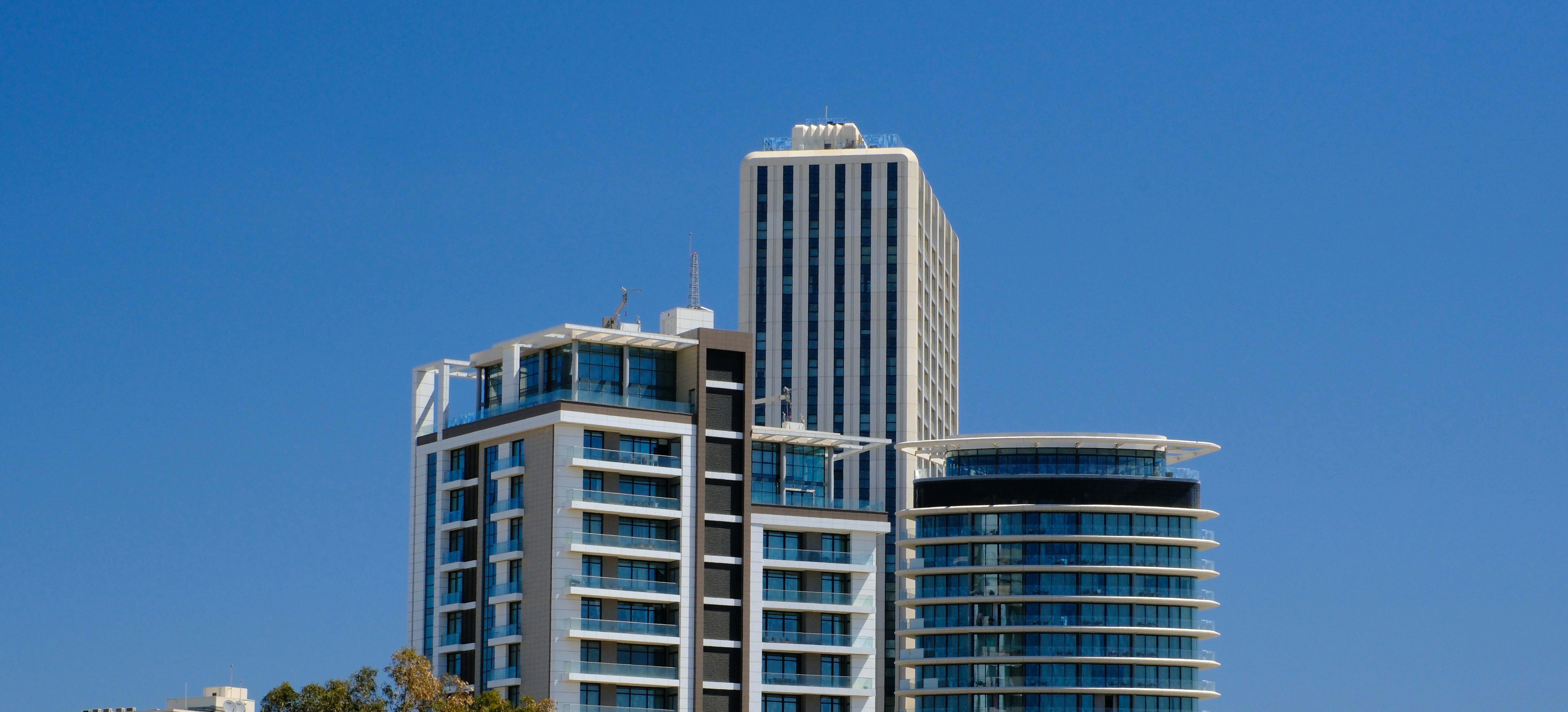 Skyline Convergence: Modern Towers Reaching Toward a Clear Blue