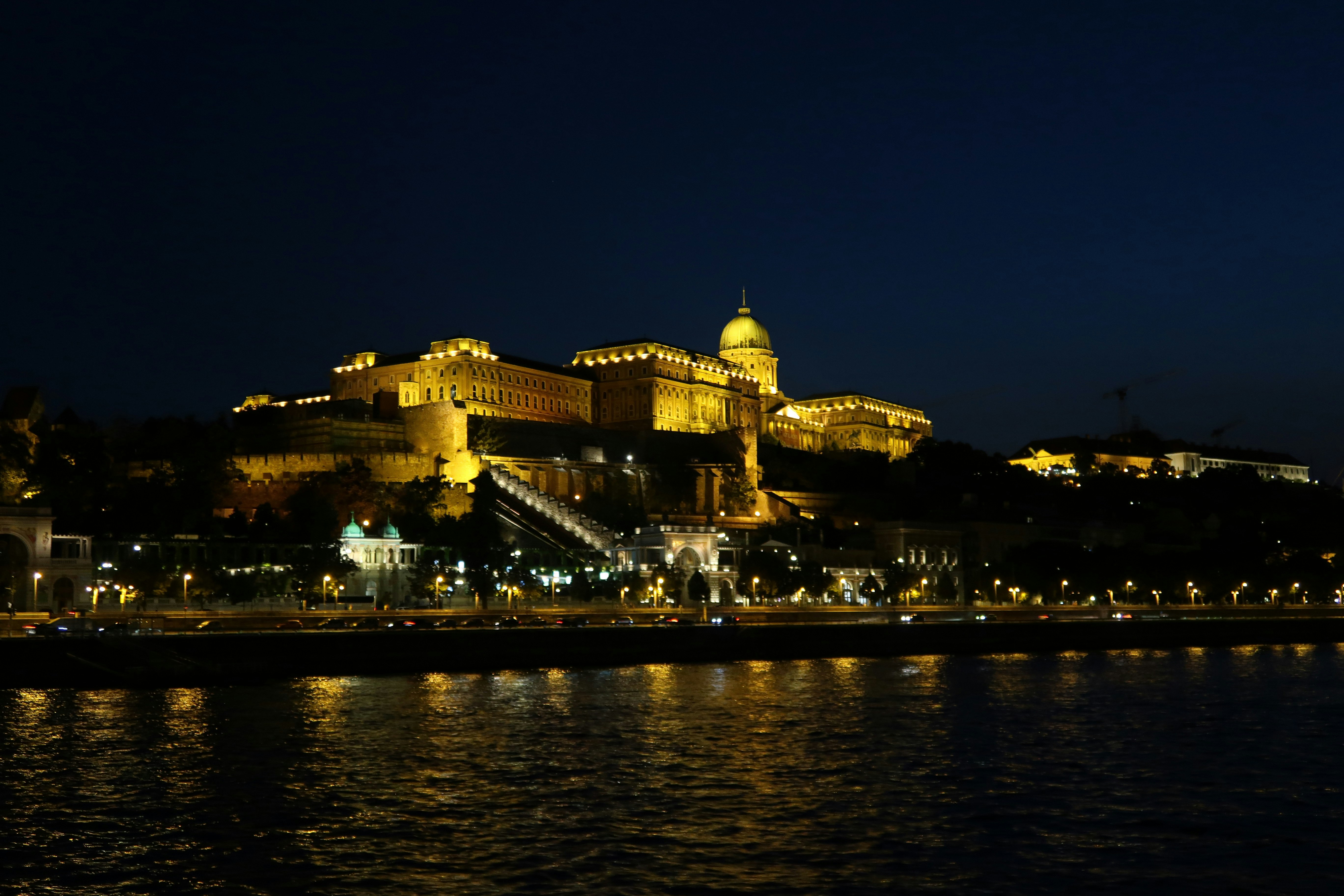 Golden Fortress by the Water: Nighttime Illumination of a Hilltop Castle