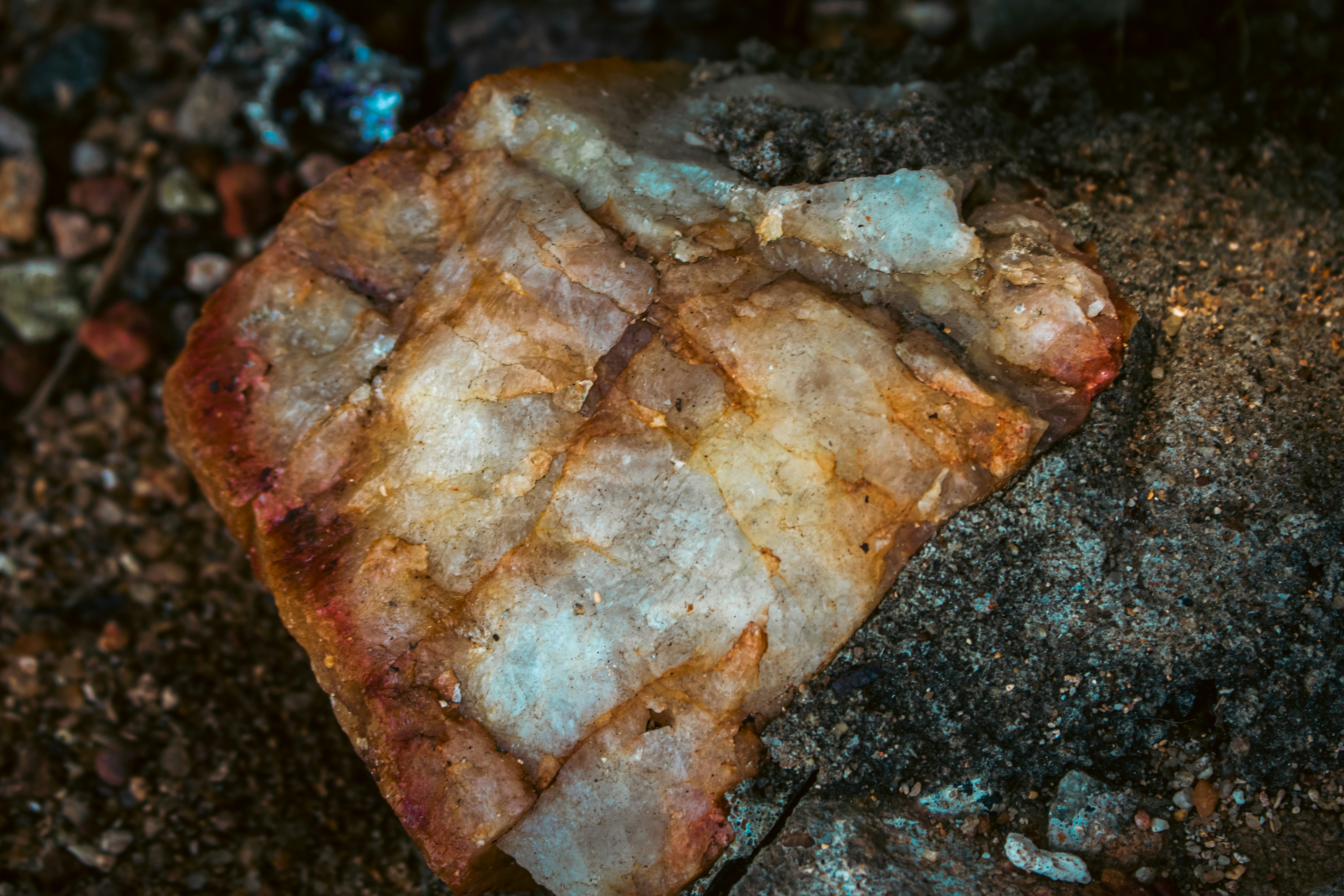 Close up photograph of a raw white quartz crystal specimen featuring translucent mineral formations and natural orange iron oxide staining. The rough unpolished texture highlights the geological character and crystalline structure of the rock. Suitable for editorial use in geology, mineralogy, gemstone identification, earth science, and natural history content.