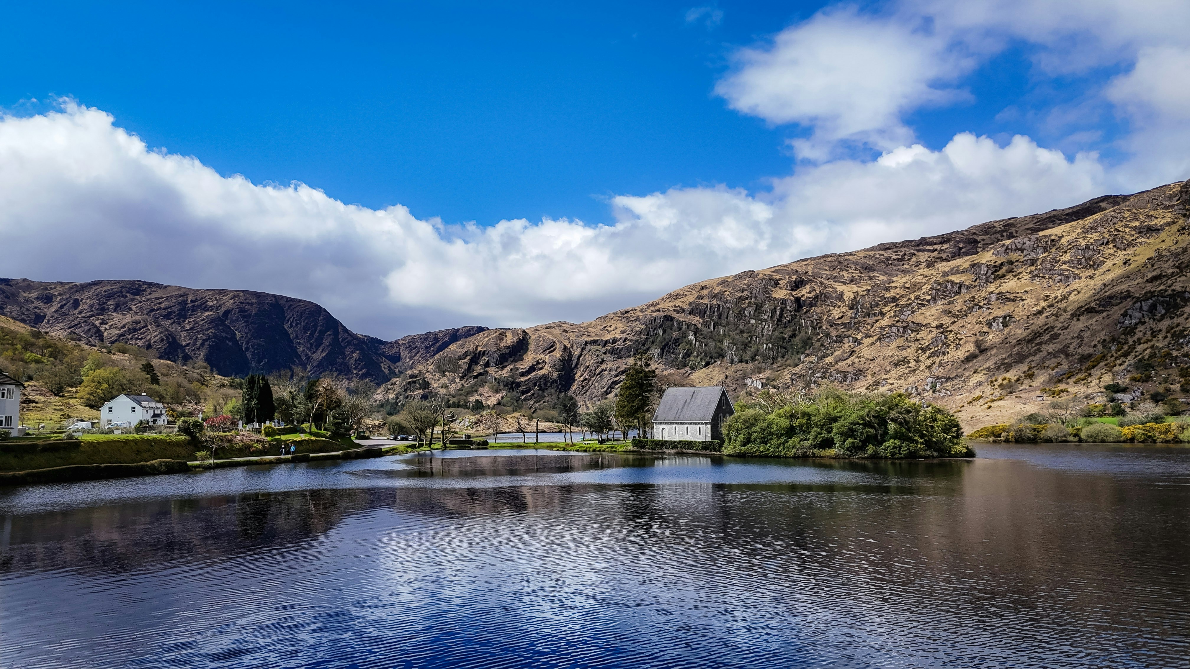 Pastoral Mirror: Calm Lakefront Village Under Open Sky