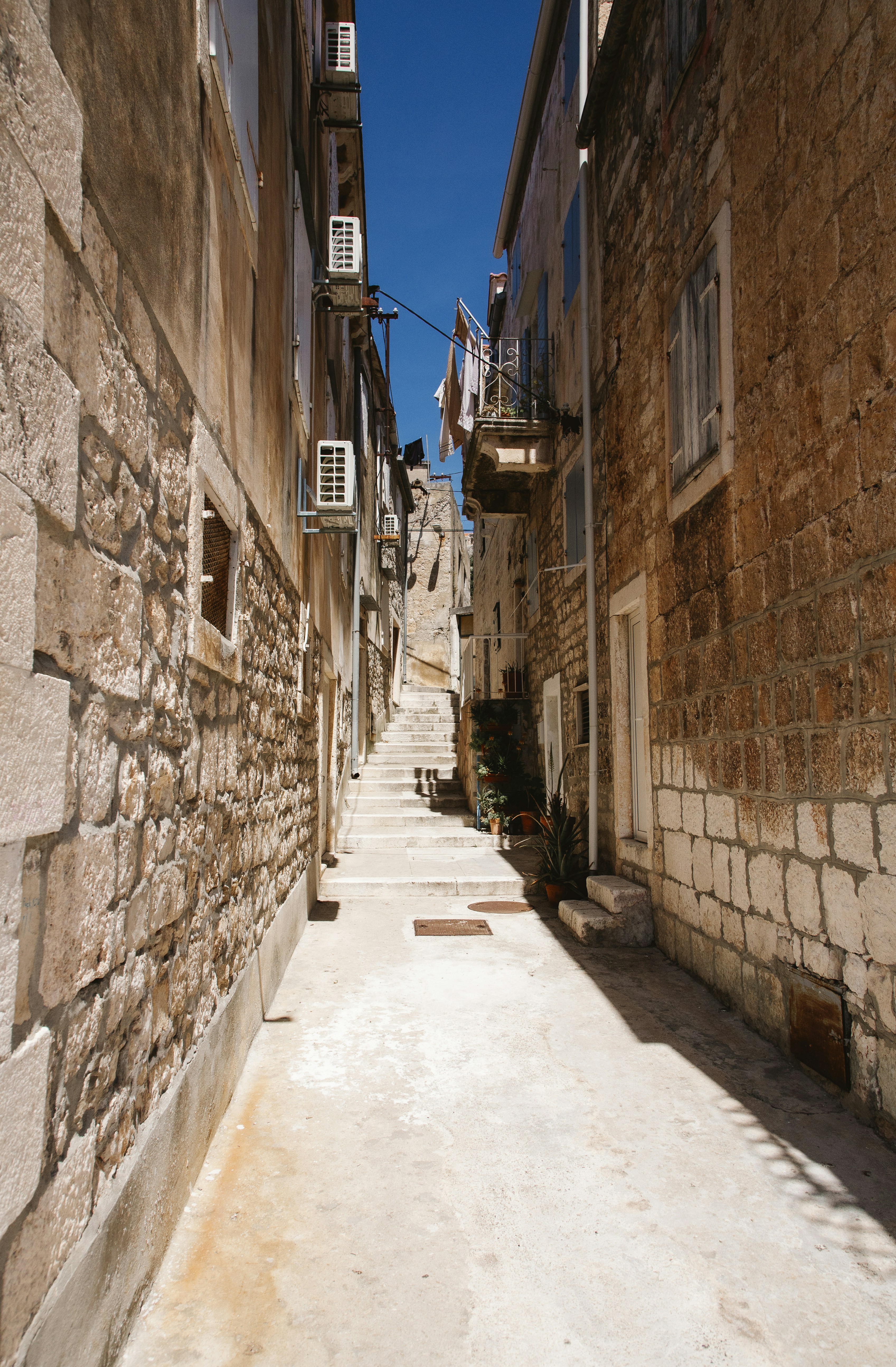 Sunlit Alleyway to a Blue Sky: Stone Walls and Stairs