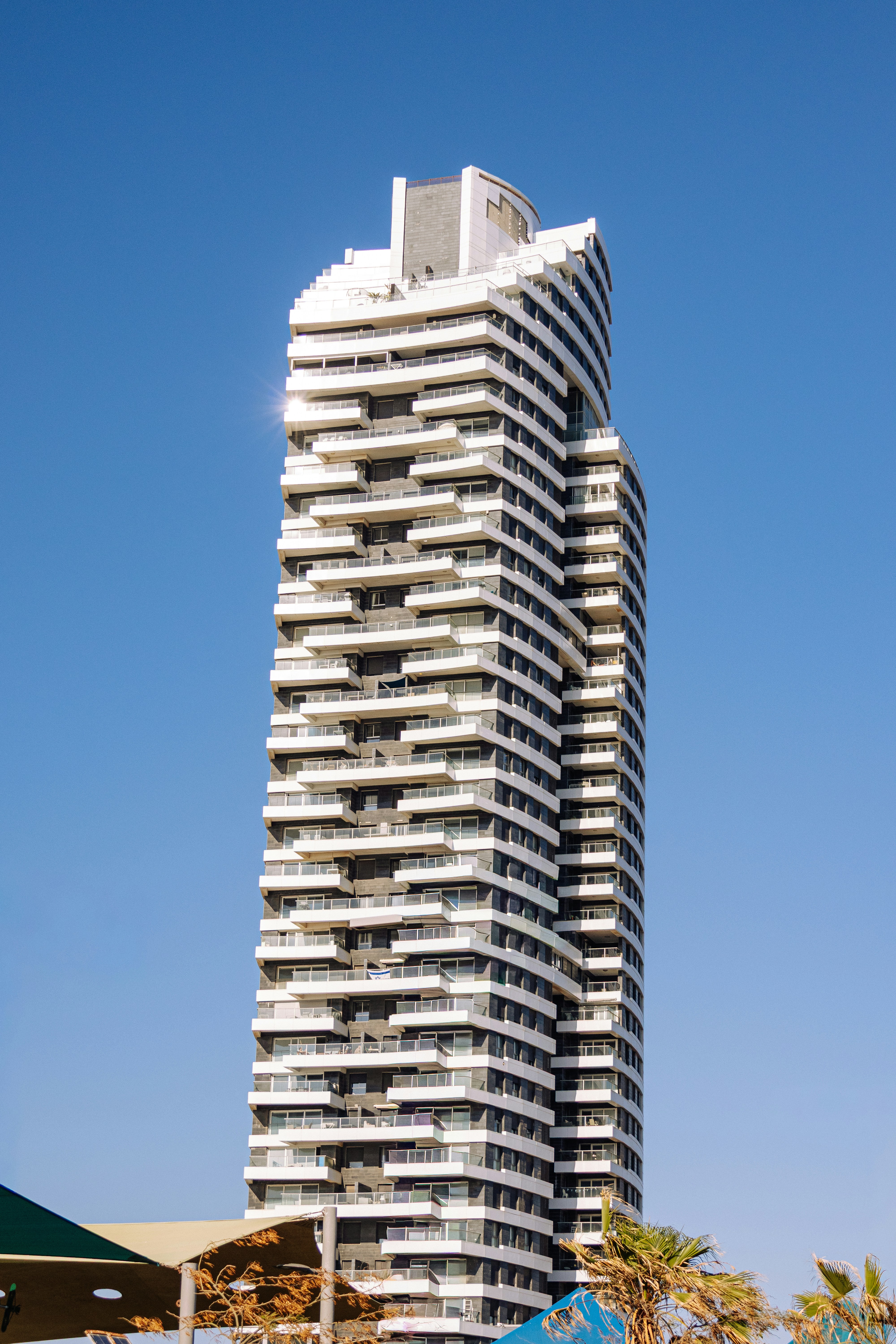 Towering Prism: A Curved-Edge Skyline Piercing a Clear Blue