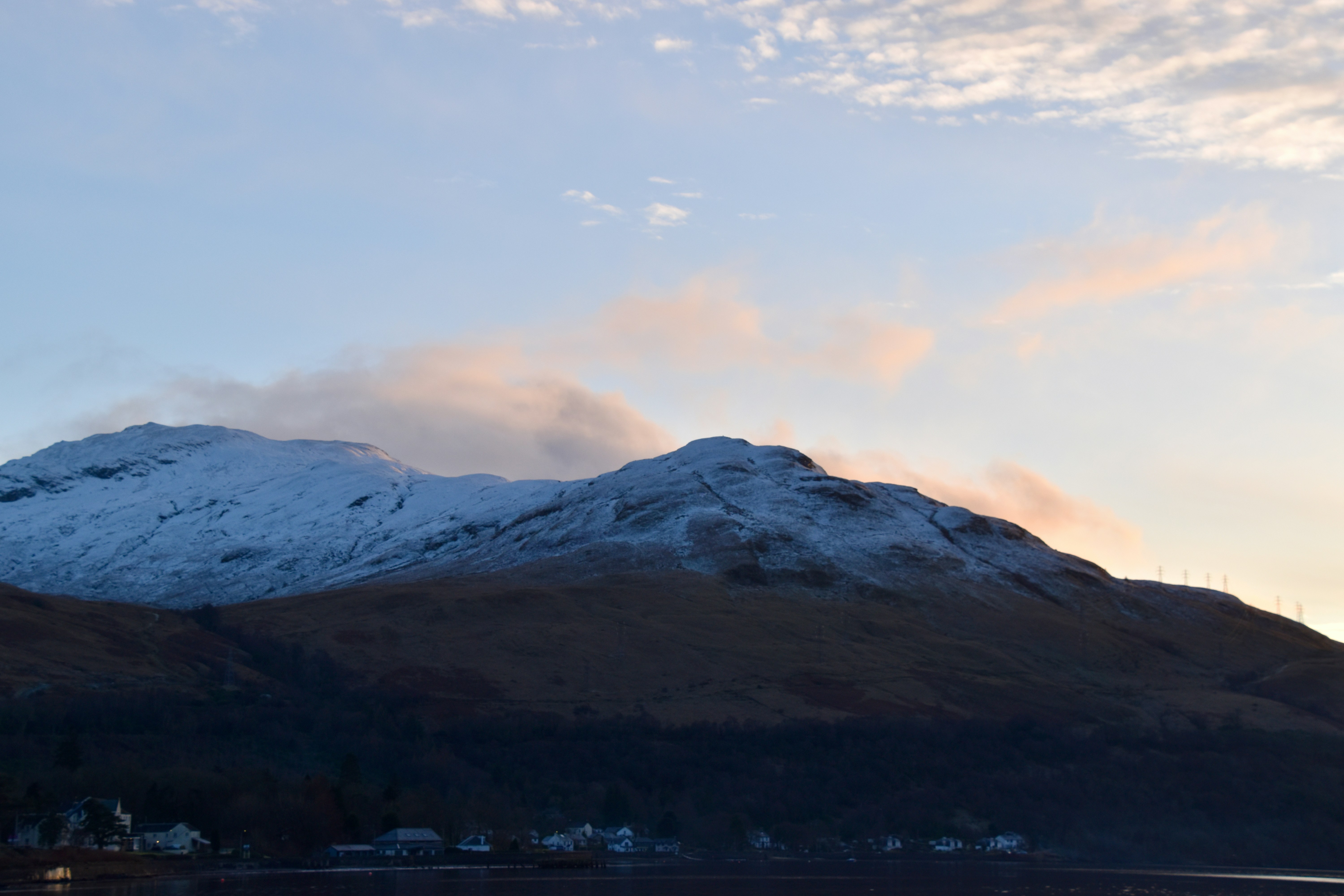 Snow-kissed ridge at dawn over a quiet lakeside village