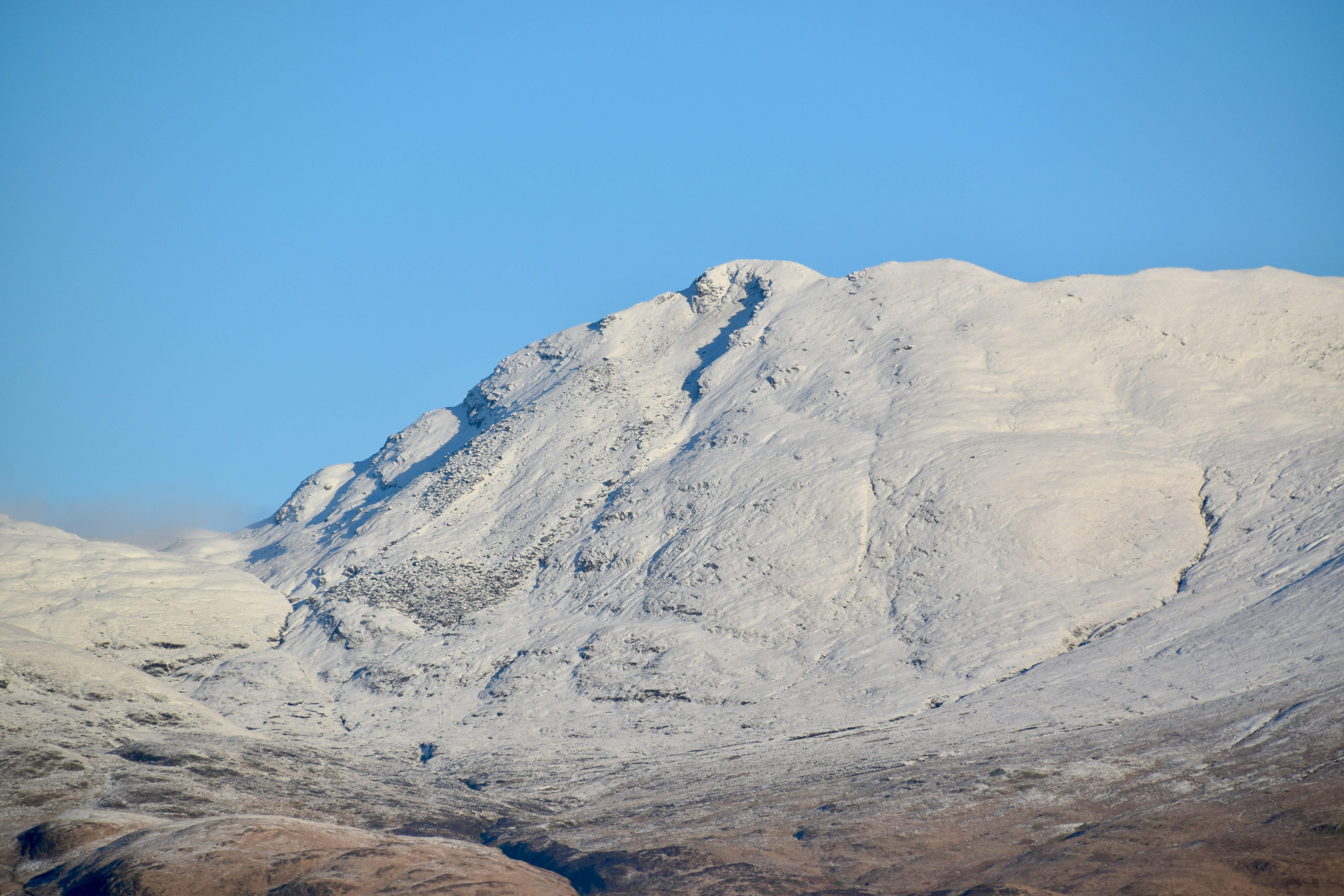 Snowbound Prominence: A Quiet Peak Under a Clear Blue Sky