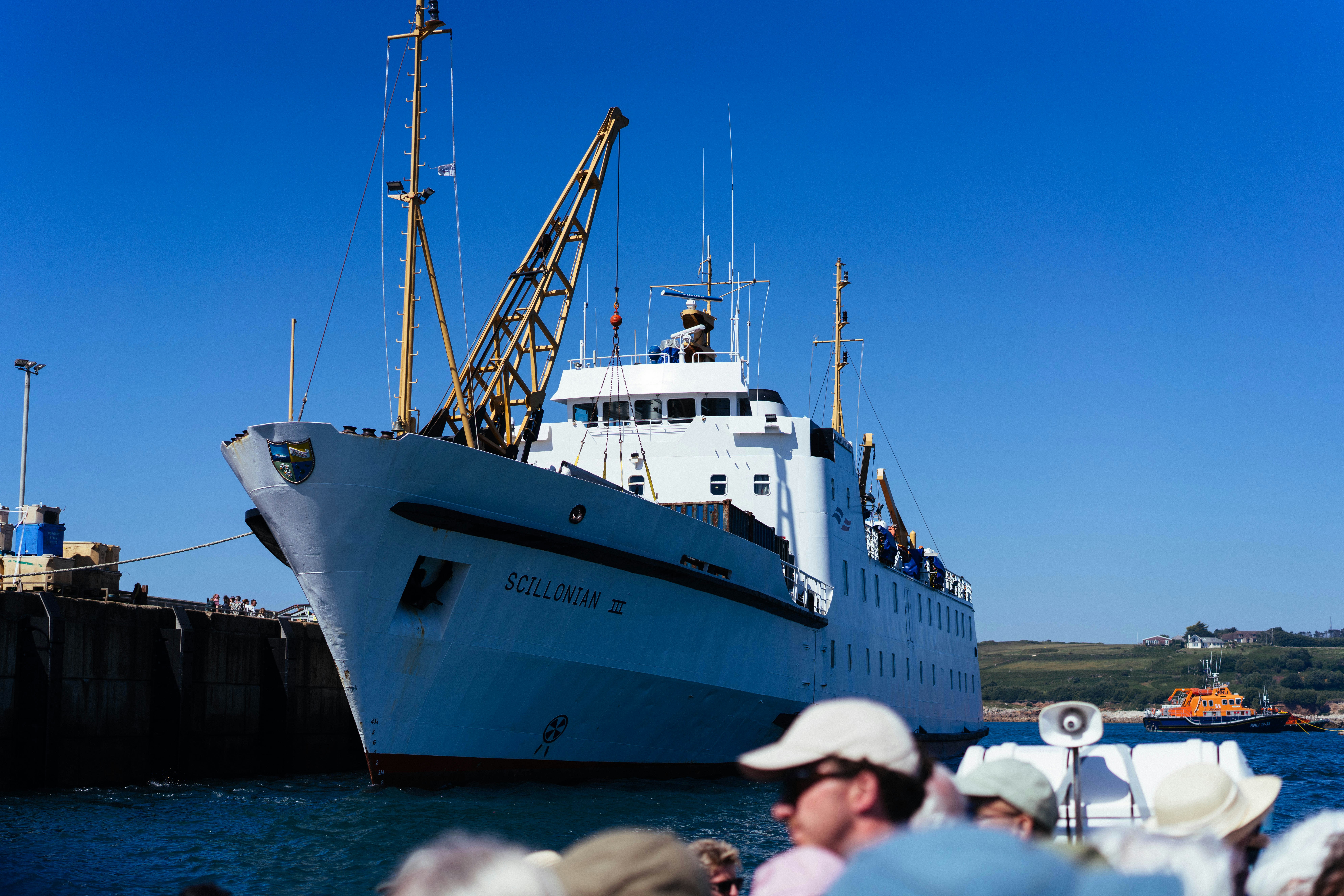 Harbor Giant: The White Vessel at Port with a Crowd in Foreground